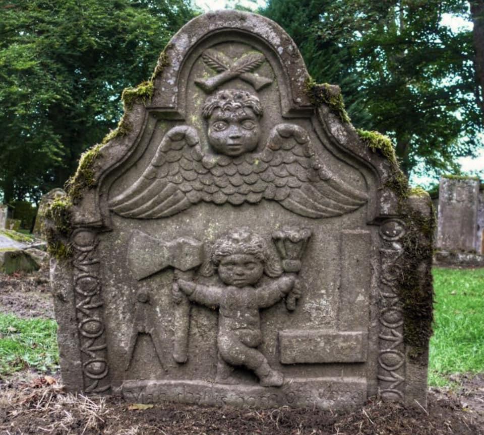 An old gravestone showing a baby carrying an axe. | Scrolller