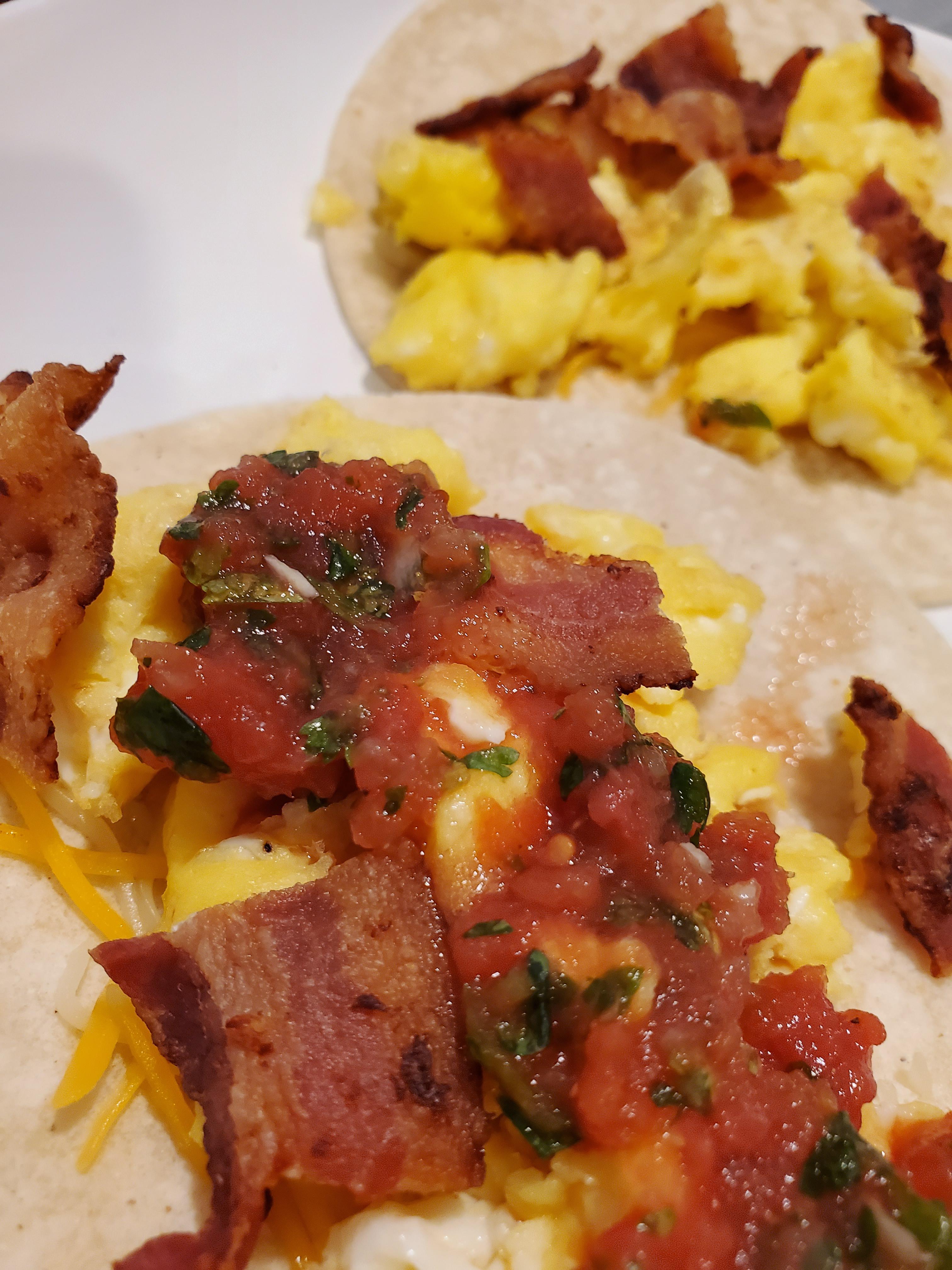 Homemade salsa on bacon, egg and cheese breakfast tacos | Scrolller