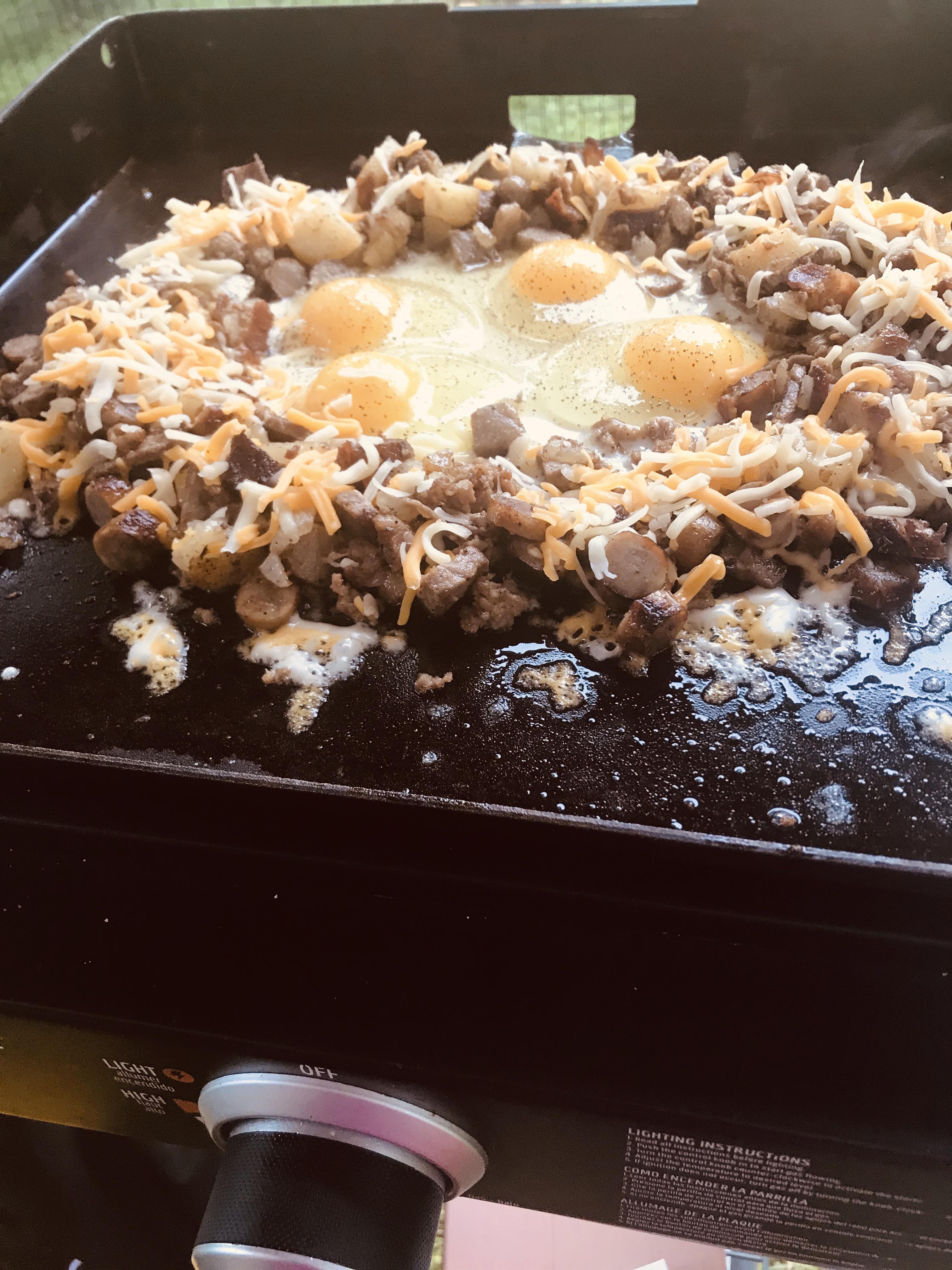 Camping breakfast on the 17 inch Blackstone. Steak, bacon, two kinds of sausage, potatoes ...