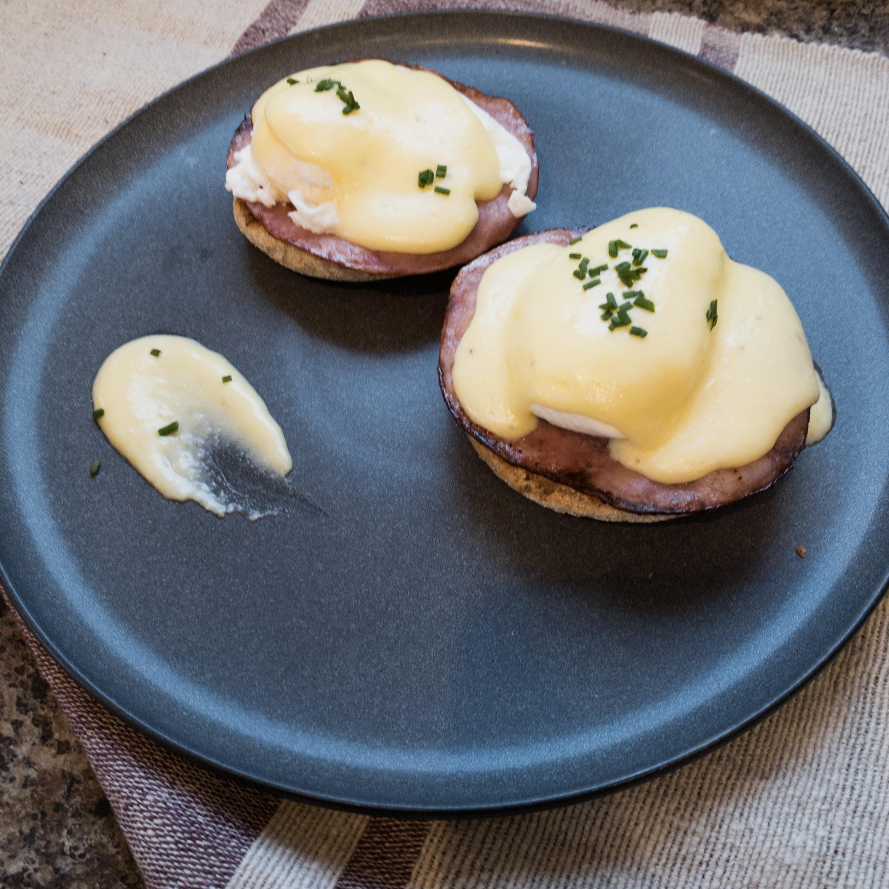 Eggs Benedict for breakfast, featuring a creamy hollandaise sauce, over a lightly poached egg ...