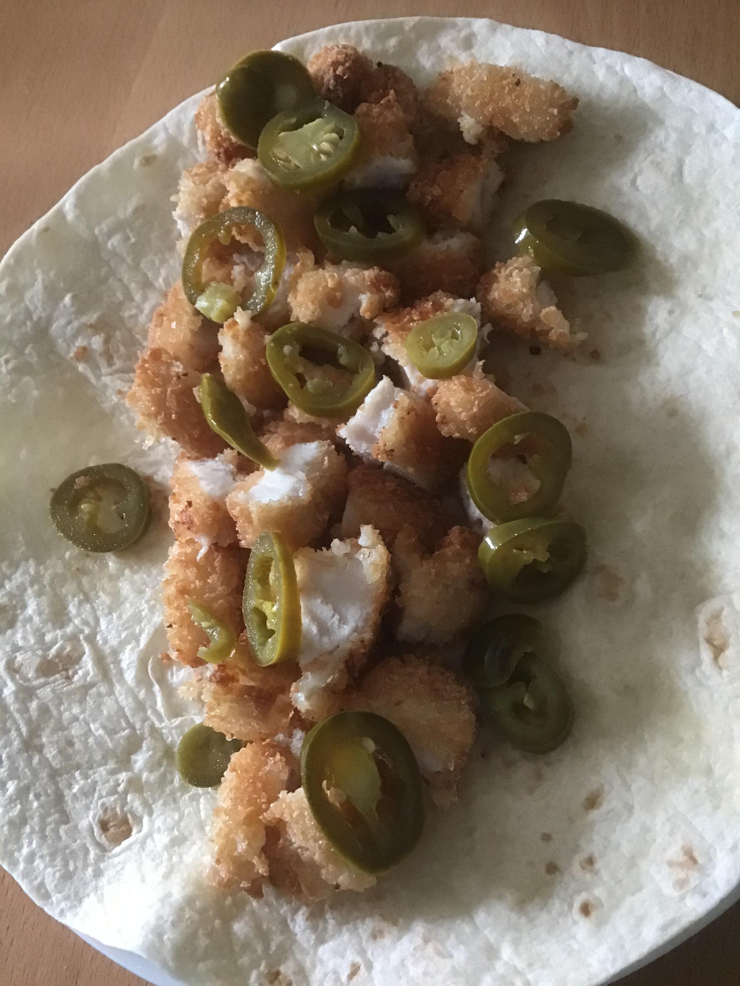 Frozen breaded chicken with tinned jalapeño on a tortilla | Scrolller