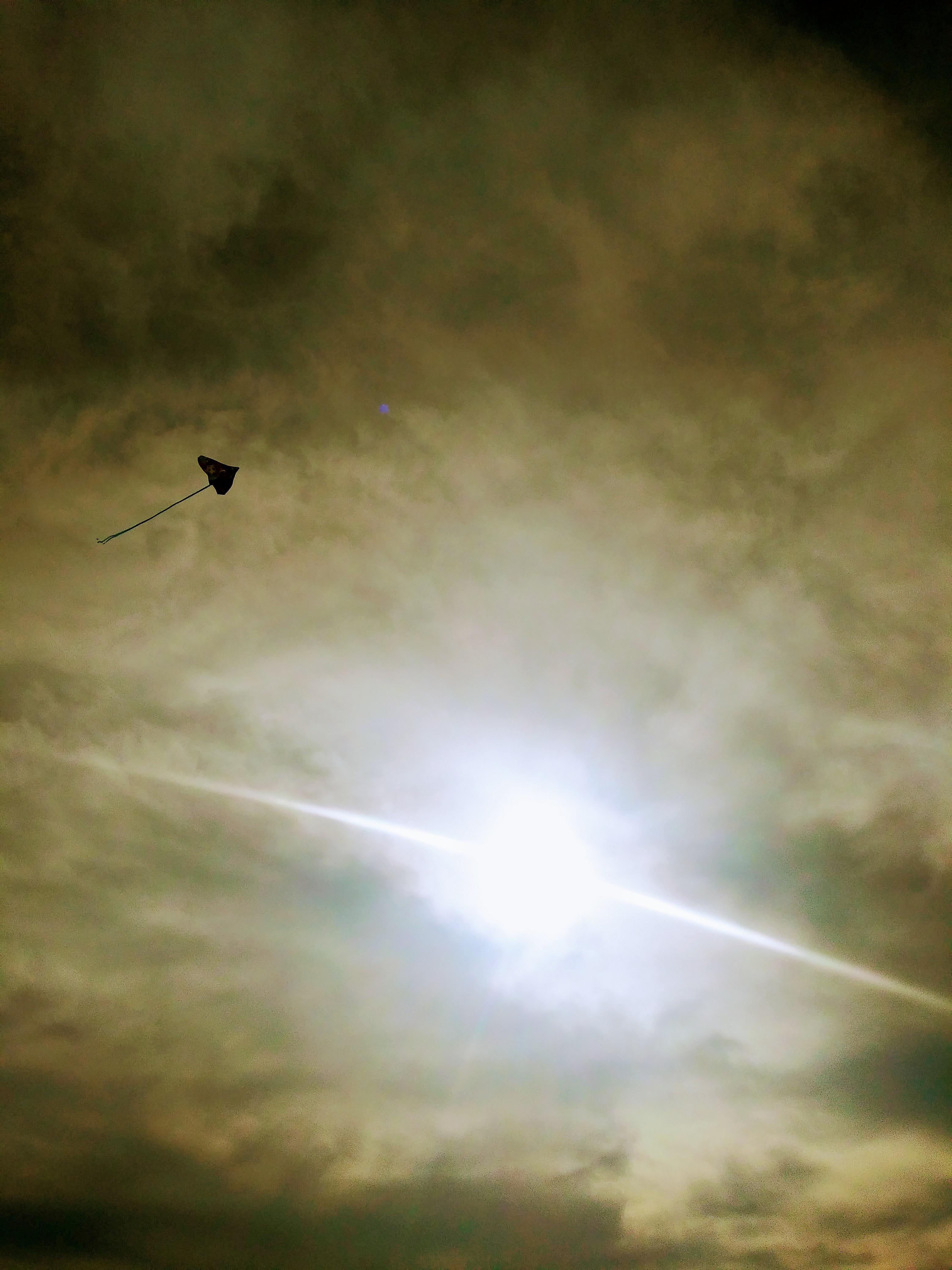 Just a kite with the sun poking through the clouds | Scrolller