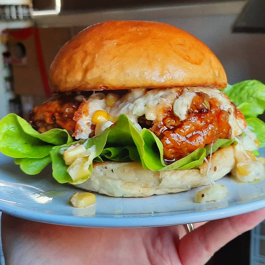 Korean fried chicken, sweet and spicy gochujang glaze, Korean corn cheese, lettuce, on a milk ...