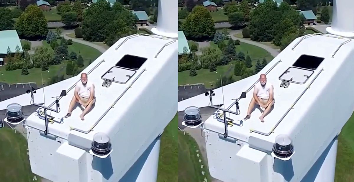 man sun bathing on a wind turbine | Scrolller