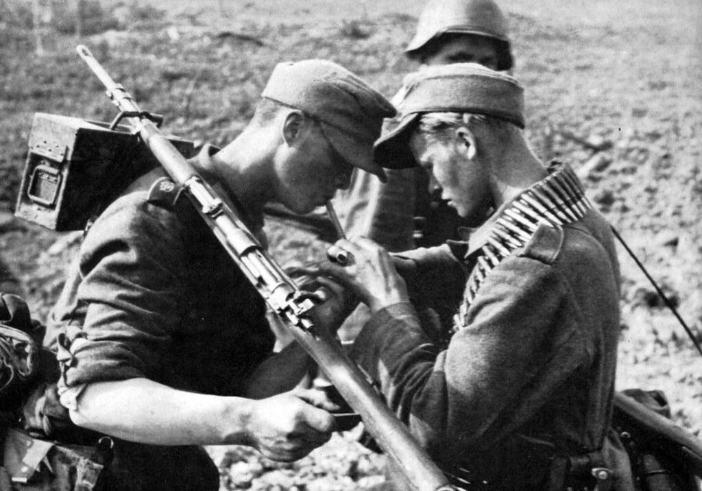 Soldiers of the Panzer-Grenadier-Division Grossdeutschland light a cigarette on the battle field ...