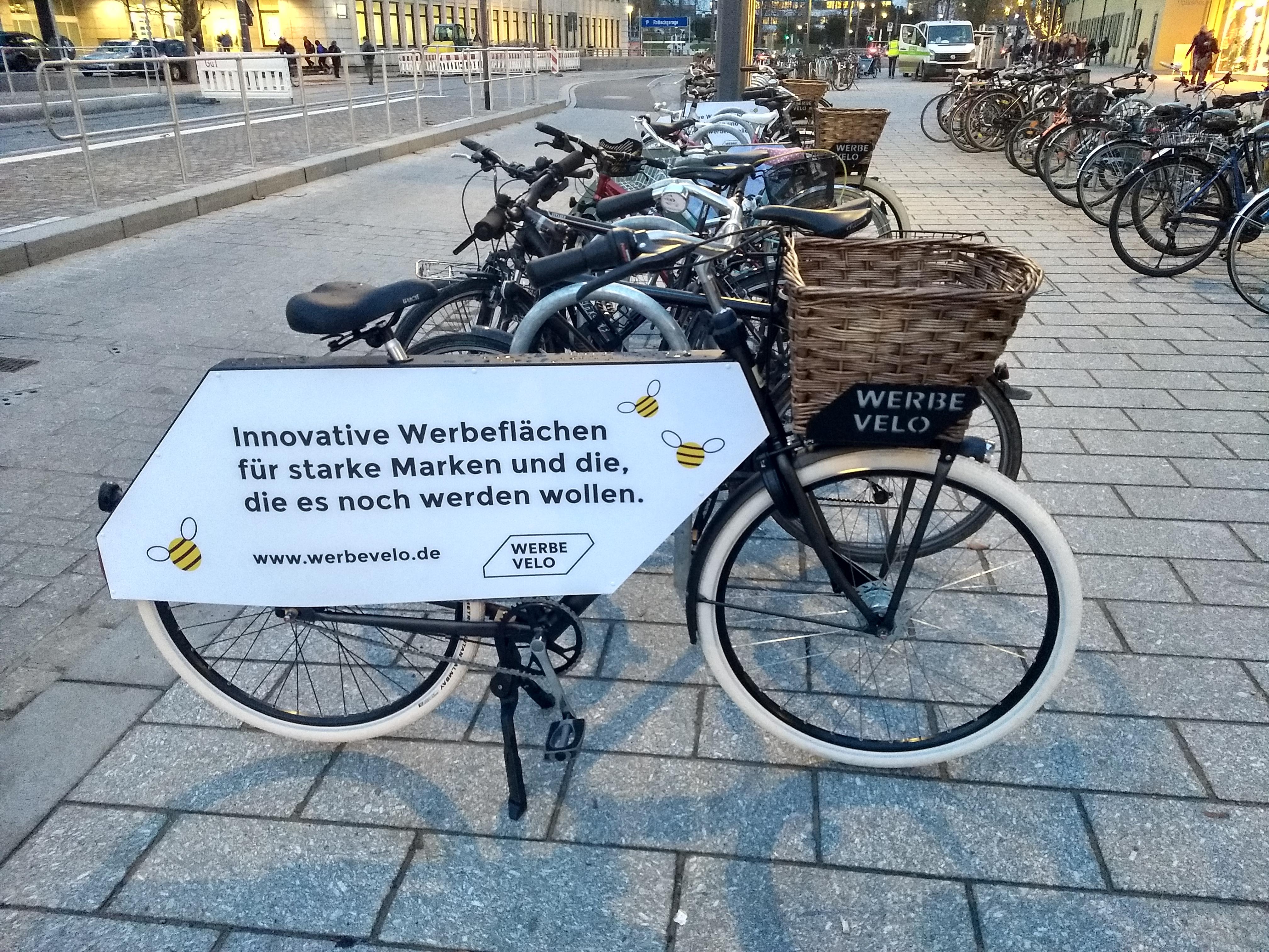 Stadt baut neue Fahrradständer in der Innenstadt. Asoziale Werbebude: Lass uns die zuparken ...