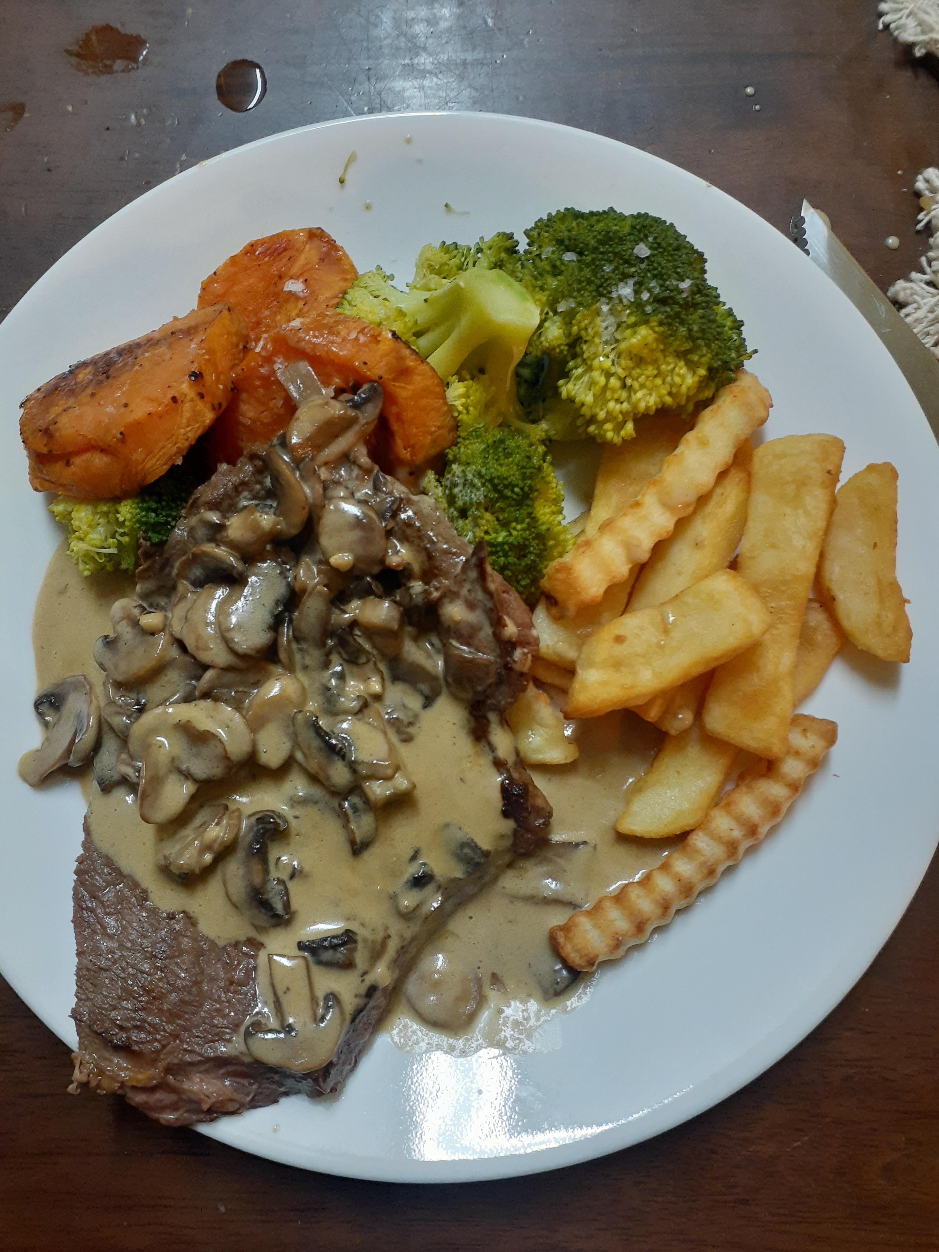 Steak with mushroom sauce, chips, broccoli and sweet potato. | Scrolller