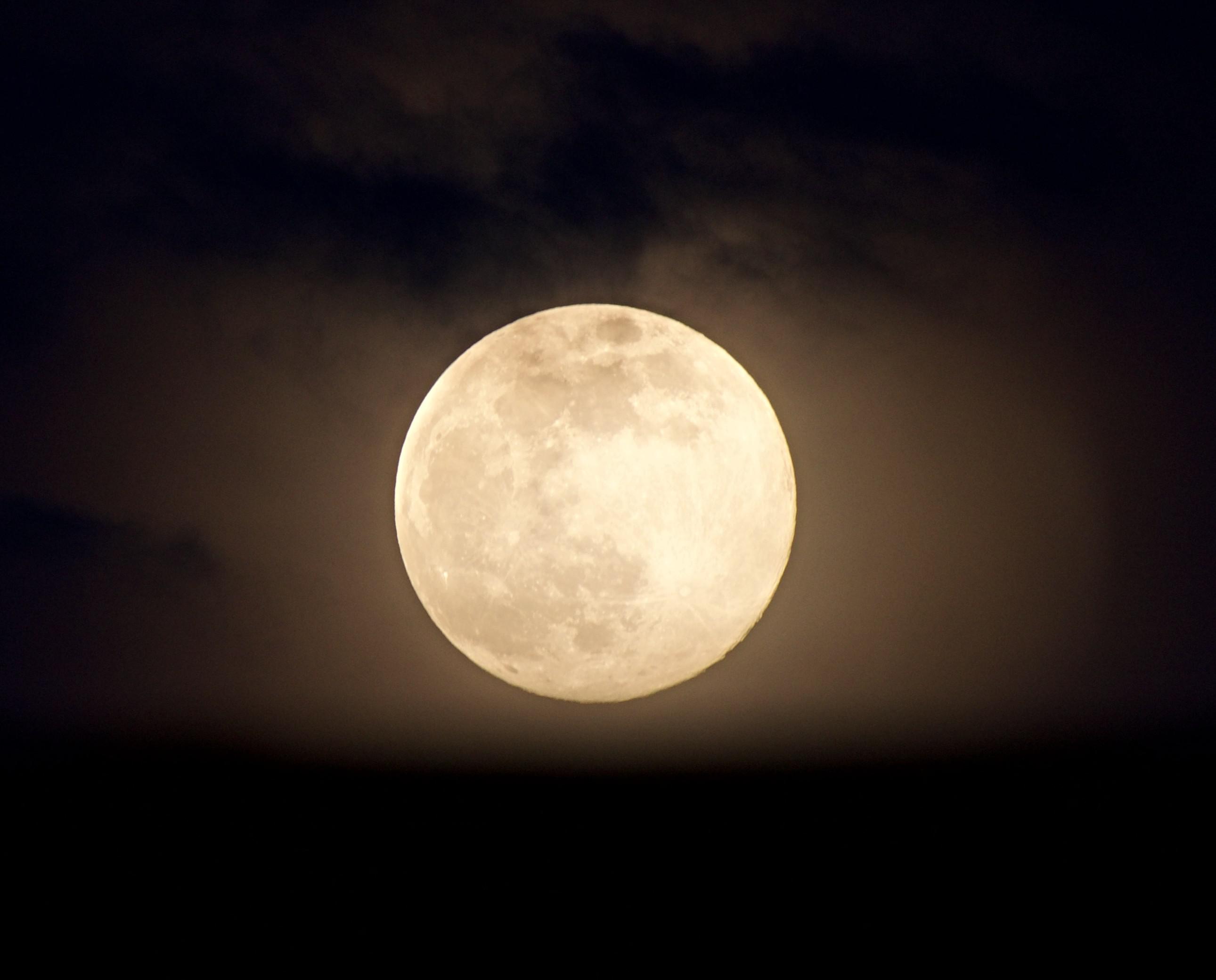 Supermoon rising over a rooftop in UK. Cloudy weather. | Scrolller