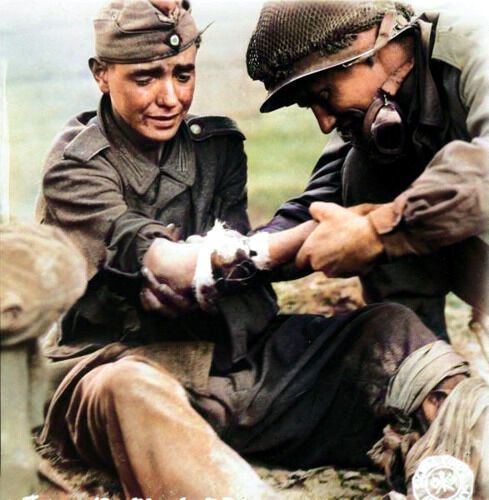 American soldier looks at wound on captured German soldier's arm. (France 1944 Colorized ...