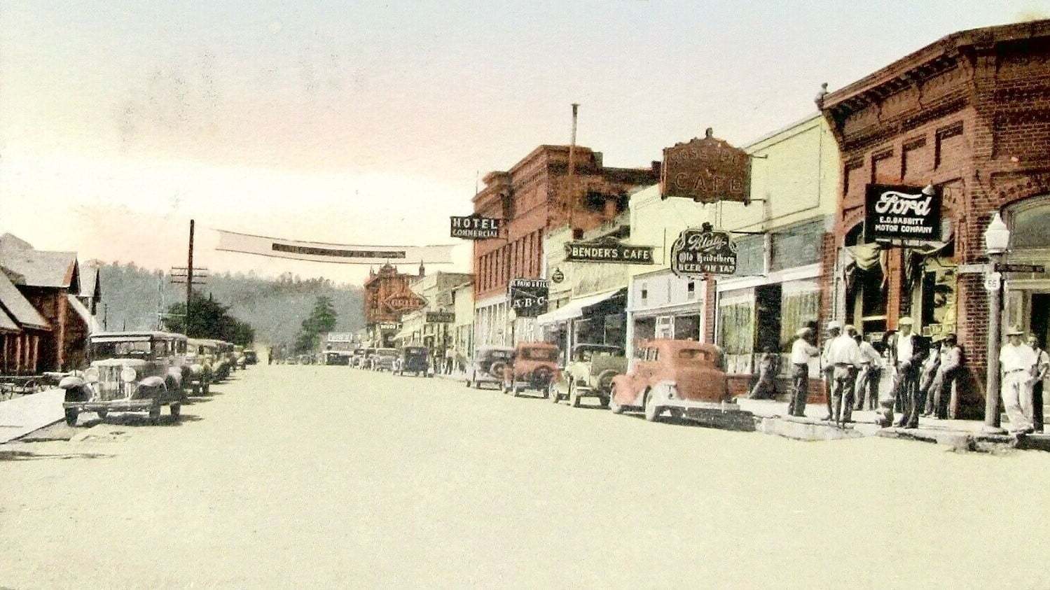 An early hand-colored postcard showing downtown Flagstaff looking west down Route 66 in the ...