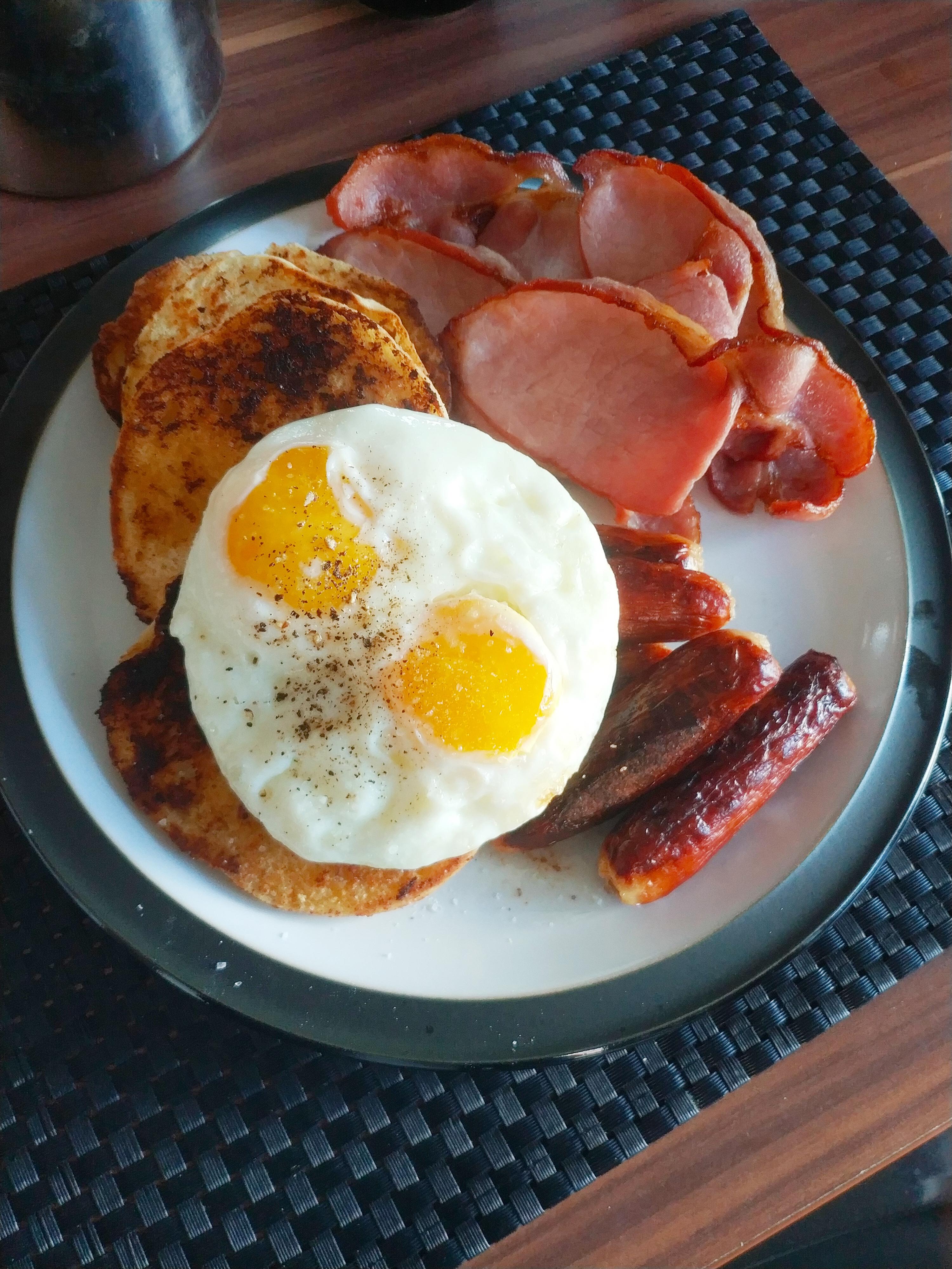 Grilled smoked bacon, oven baked sausages, shallow fried eggs, muffins fried with bacon fat and ...