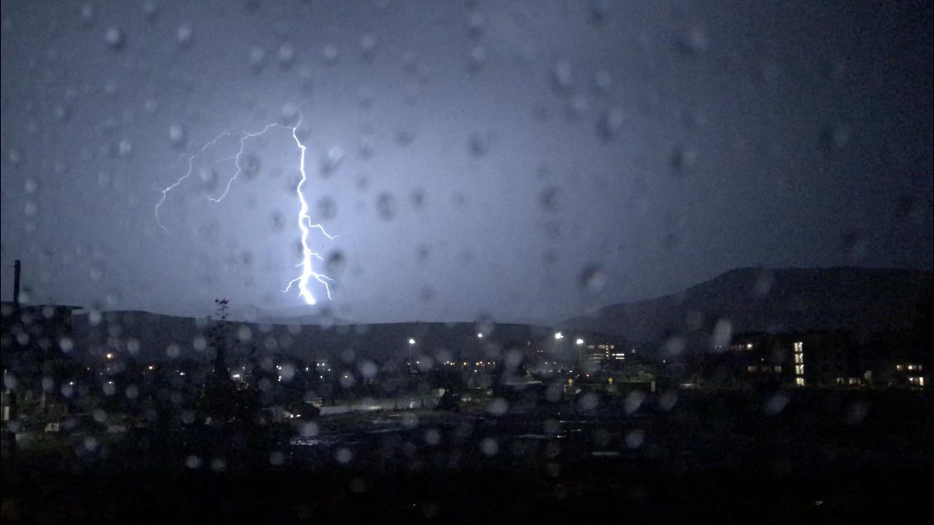 Lightning strike through rain covered window. | Scrolller