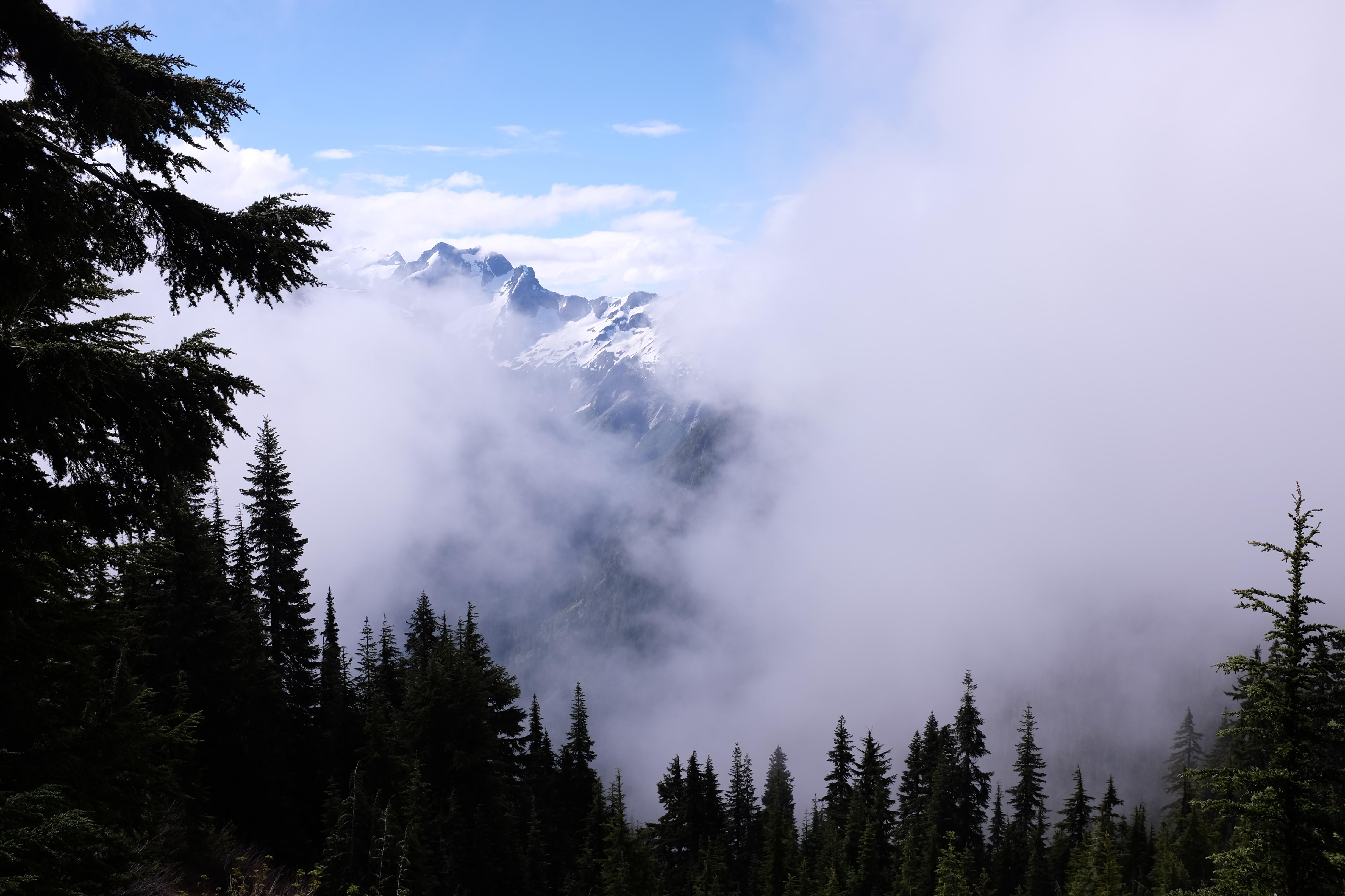 Mountains peeking through the clouds in the Cascades | Scrolller