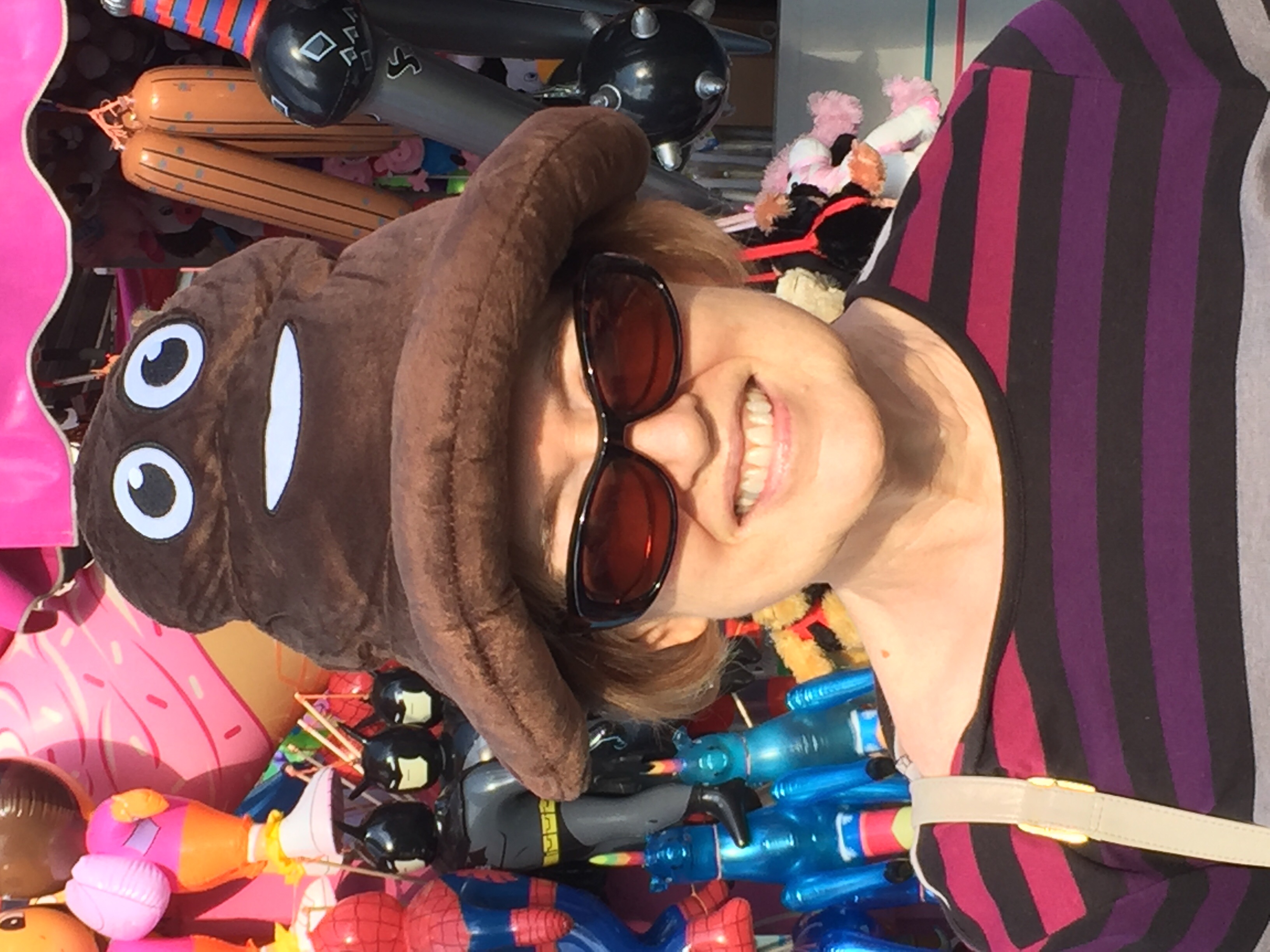 My mom wearing a poop emoji hat at the state fair. | Scrolller