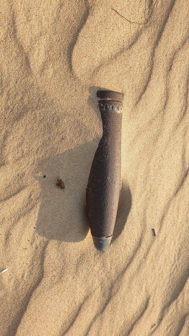 Rusted artillery shell seen half buried in the dunes close to Dubai, UAE. About 50cm long x 10cm ...