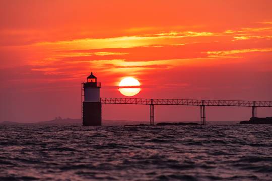 Sunrise behind a lighthouse | Scrolller