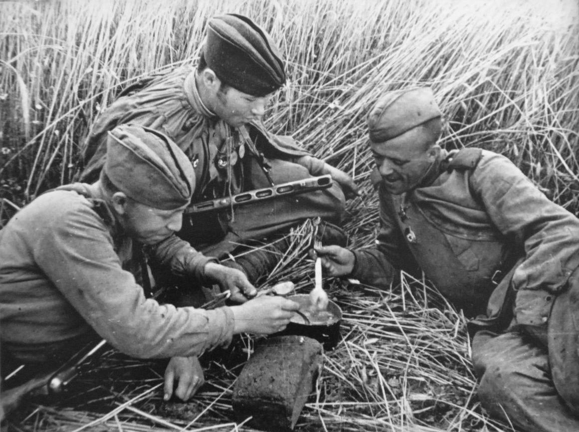 Three Soviet guard soldiers, at lunch. No information about date and place. | Scrolller