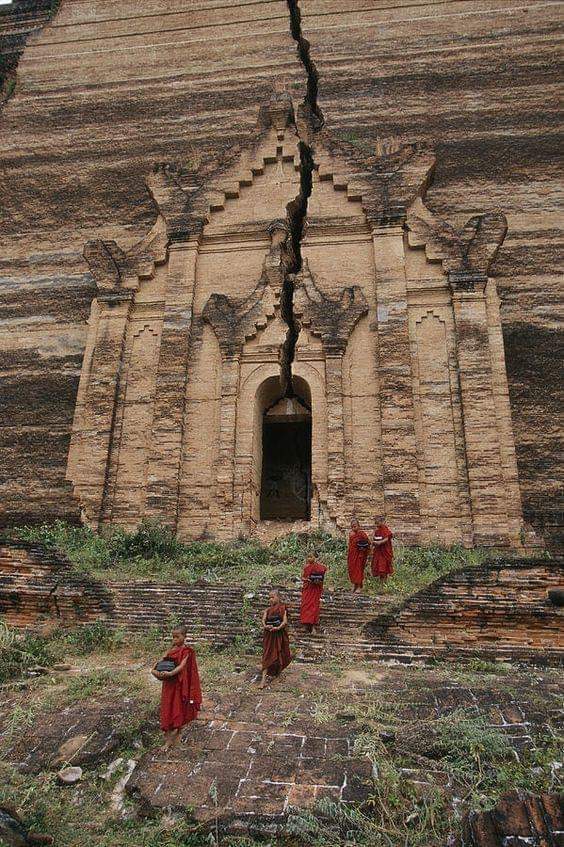 Young Buddhist monks leaving a ruined temple | Scrolller