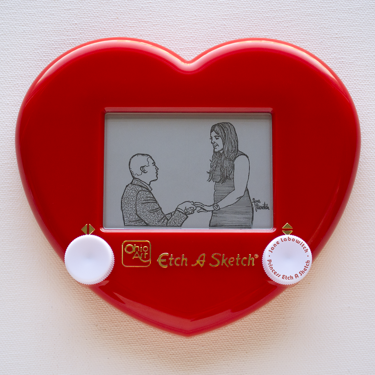 A couple rendered on a heart-shaped Etch A Sketch | Scrolller