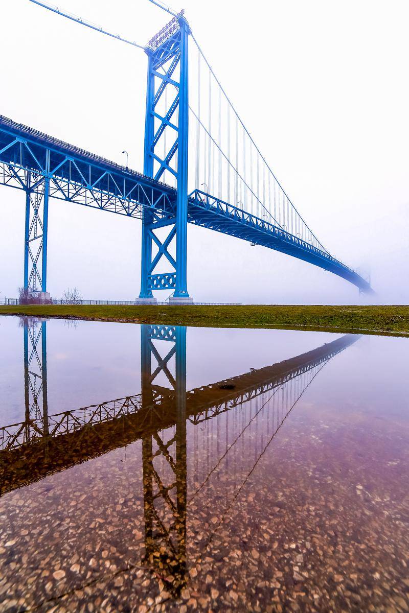 Ambassador Bridge reflection in a puddle on a foggy day! | Scrolller