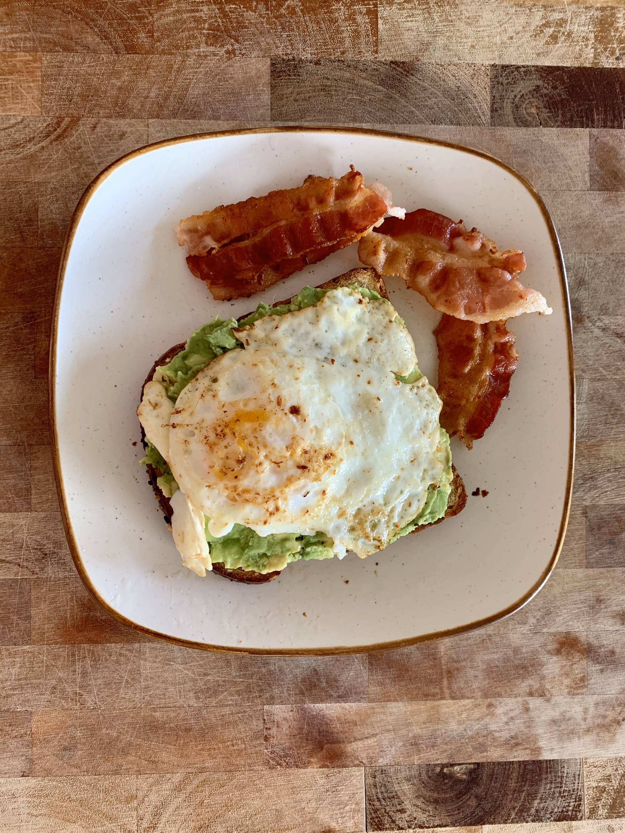 Avocado toast with an over easy egg and bacon. | Scrolller