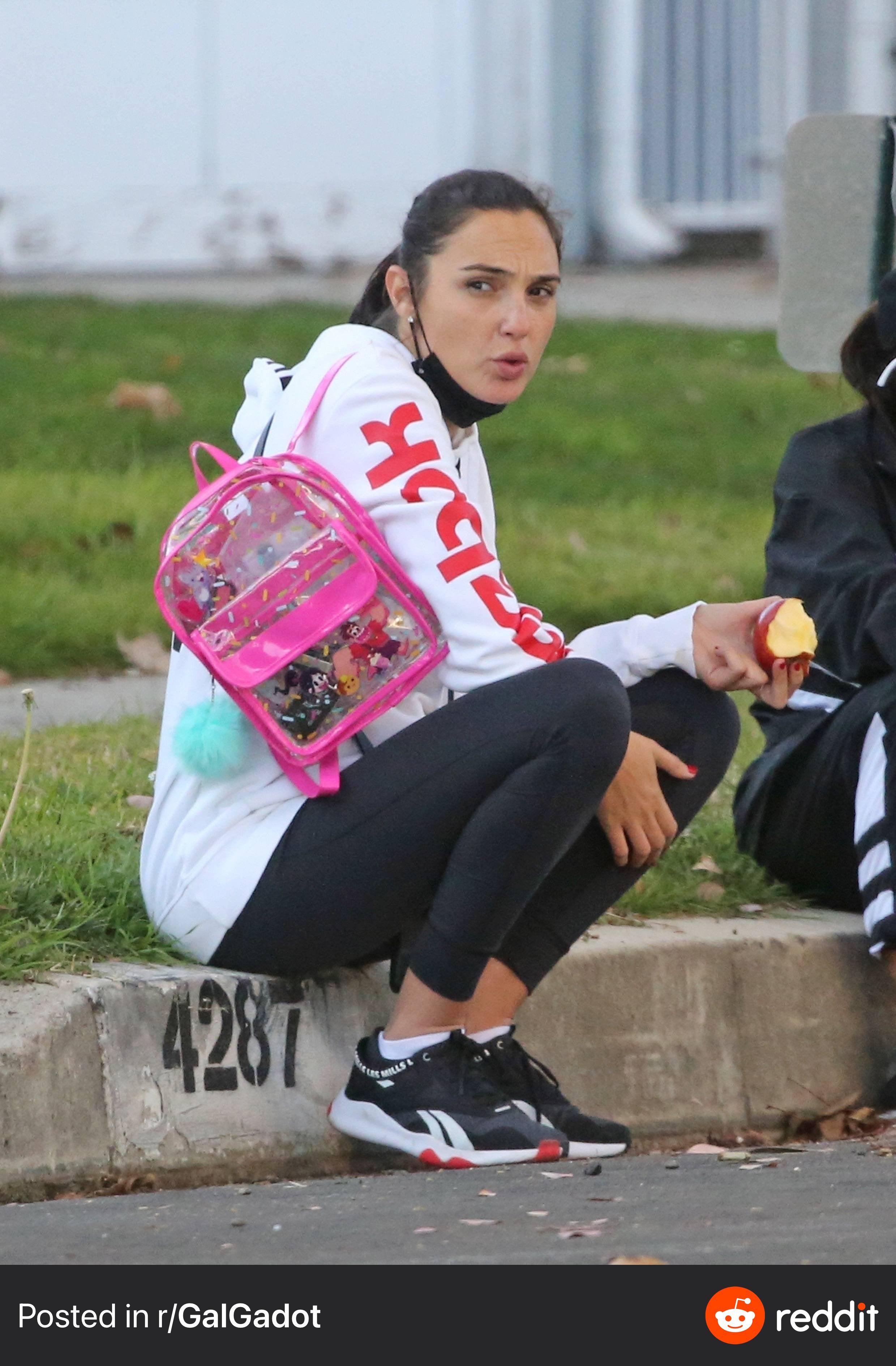 Gal Gadot sitting on the sidewalk looking like a street hooker who'll suck you off in your car ...