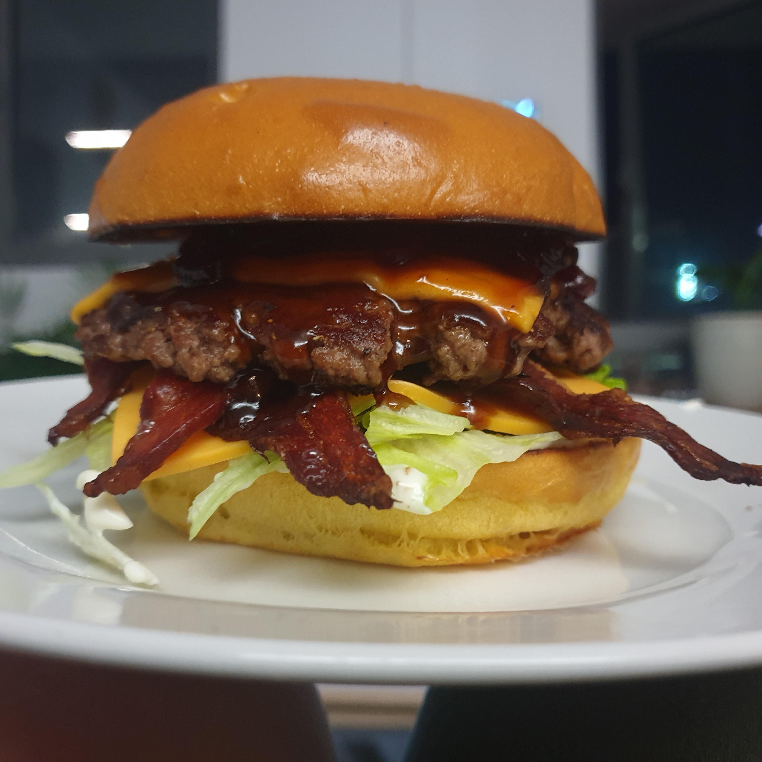 Homemade beef brisket burger, smoked bacon, caramelised onions, lettuce, cheese, mayo & BBQ ...