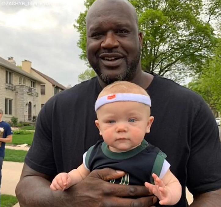 Shaq holding a human child | Scrolller