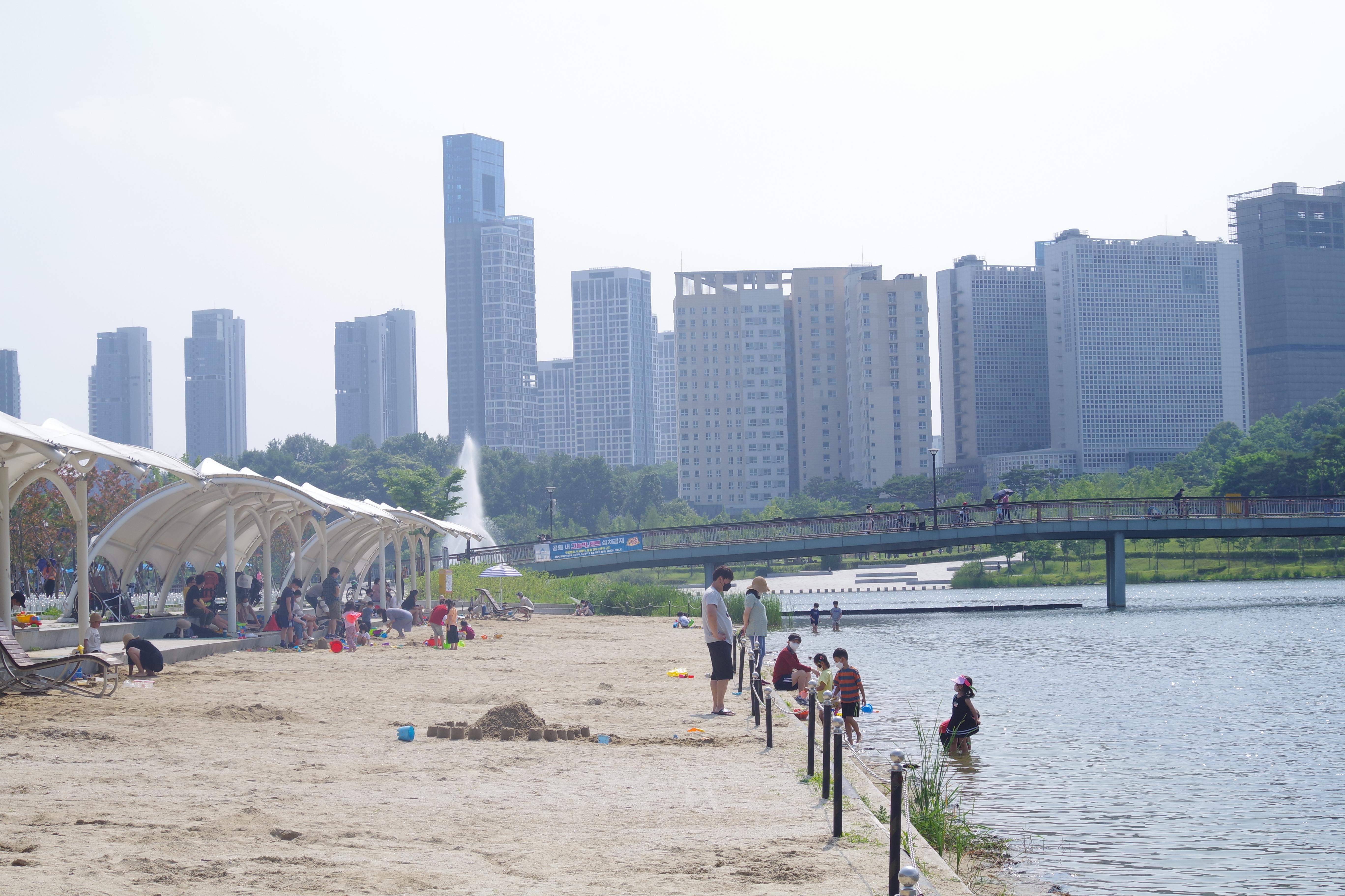 Families enjoy the beach in Sejong's Central Park. | Scrolller