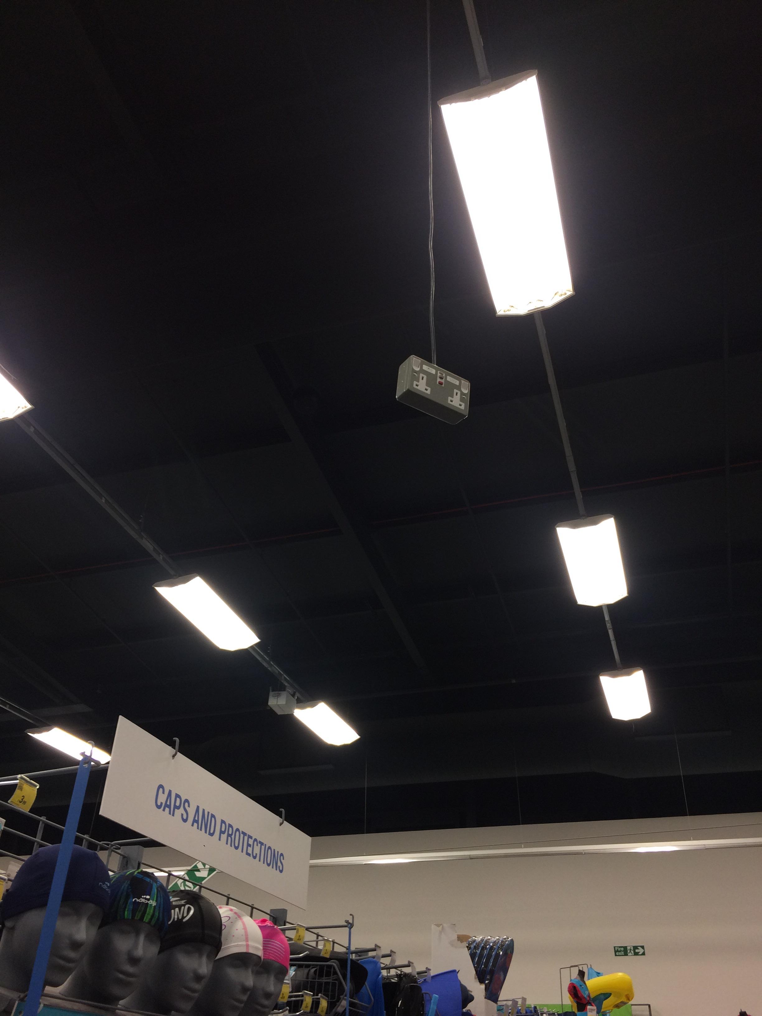 Hanging from the top of an outdoor activities shop with very high ceilings | Scrolller