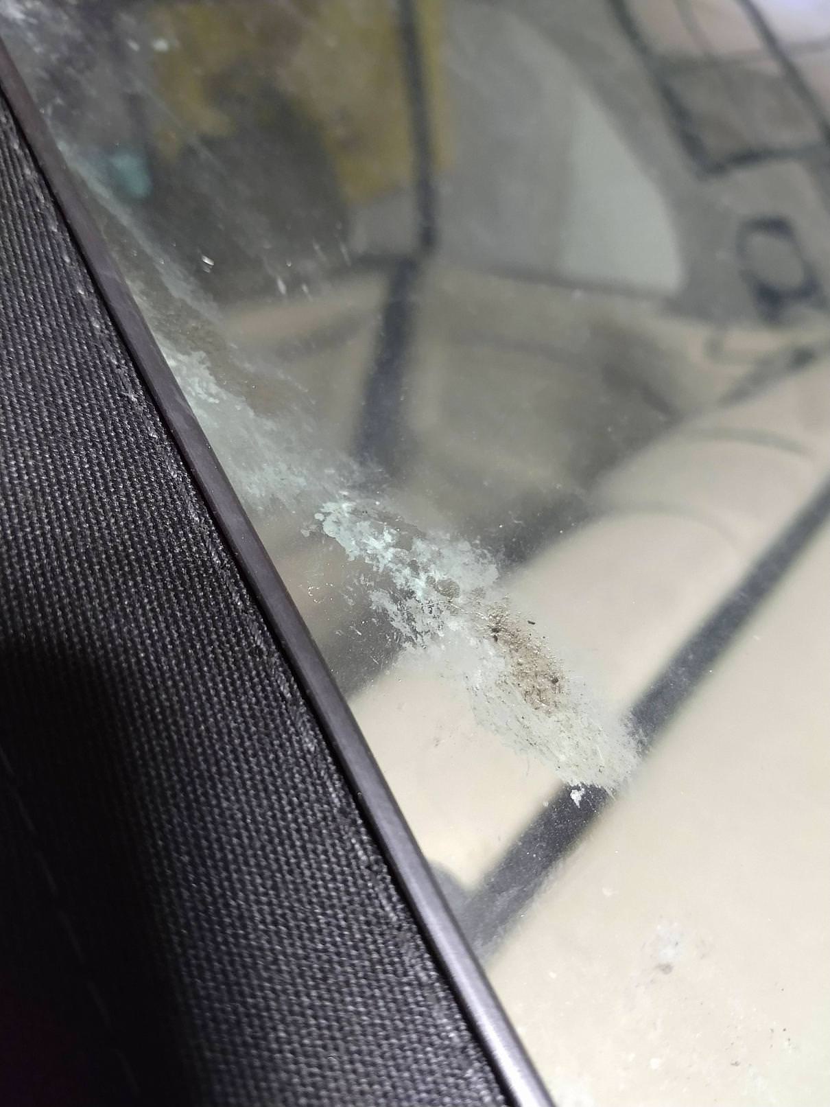 How can I remove the light adhesive material without damaging the window? | Scrolller