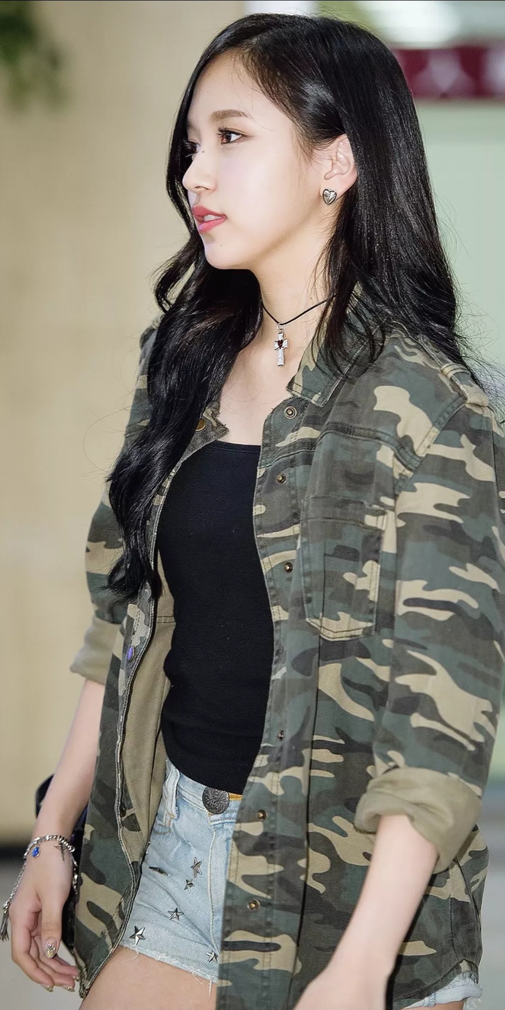 Mina - jean shorts, black top, camo jacket | Scrolller