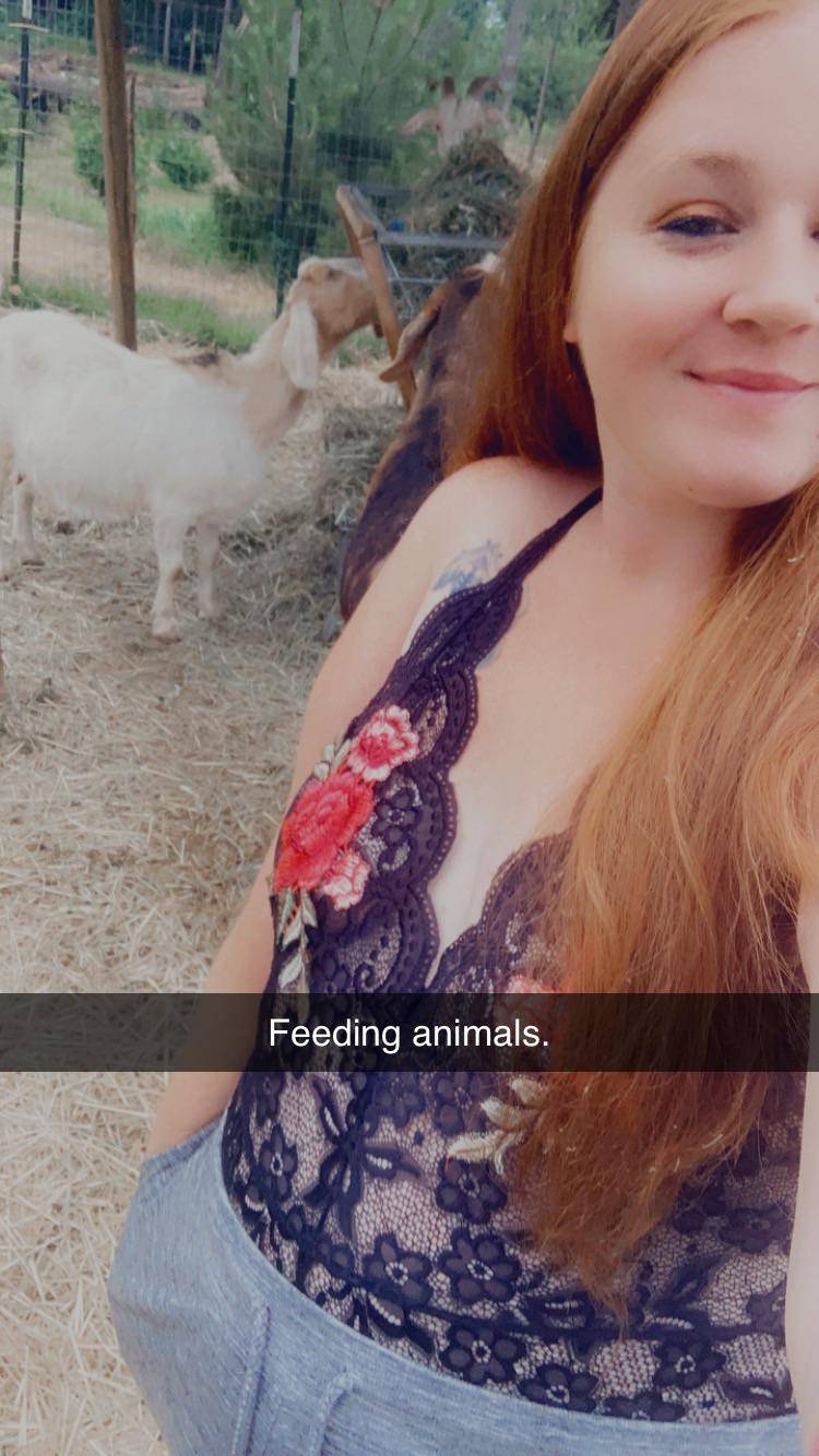 Out feeding the goats. | Scrolller