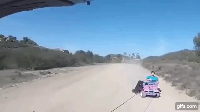 Tying a kids car to the back of a real car and riding it down a dirt road, genius! | Scrolller