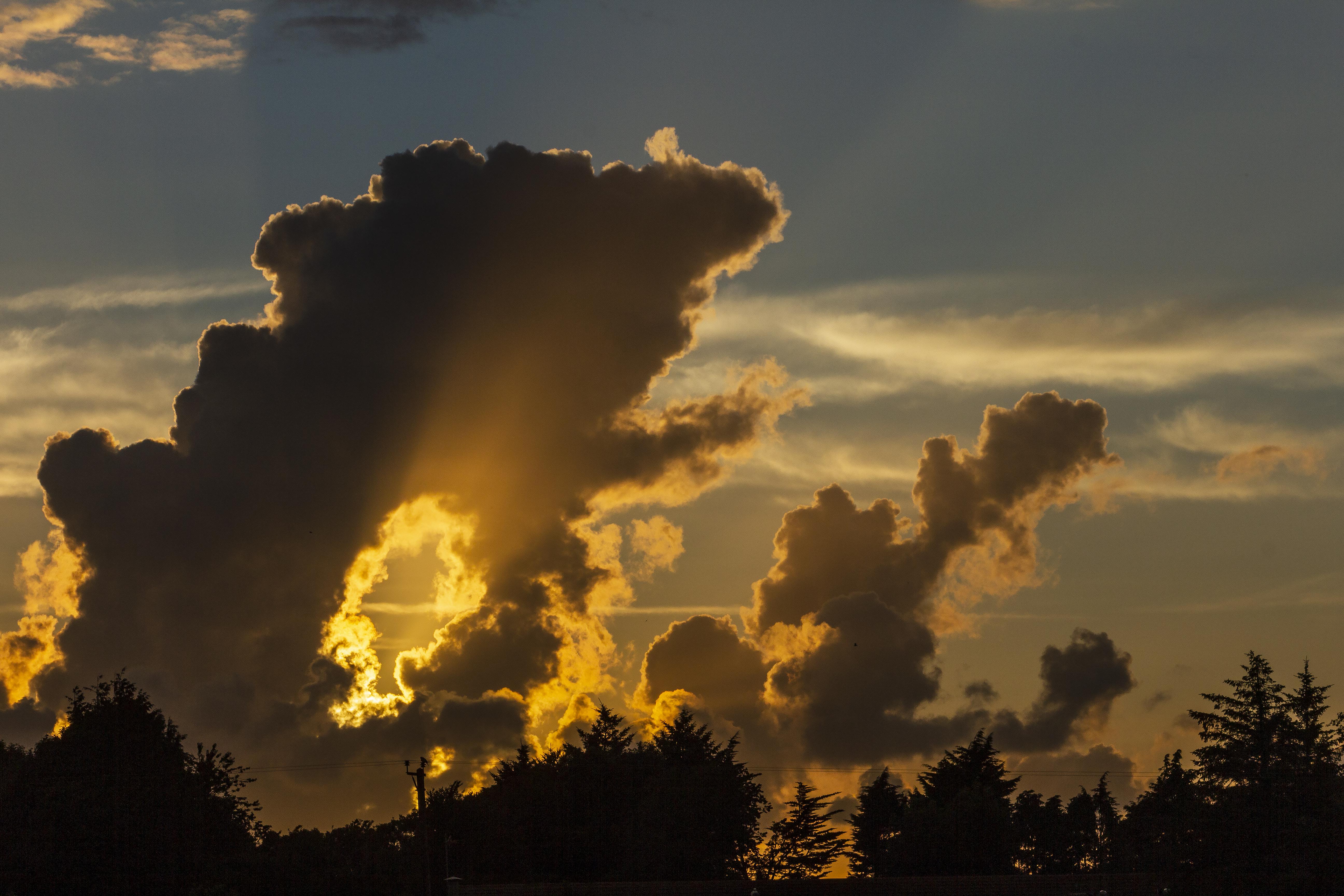 Unusual cloud formation giving upward shining suns rays at sunset ...