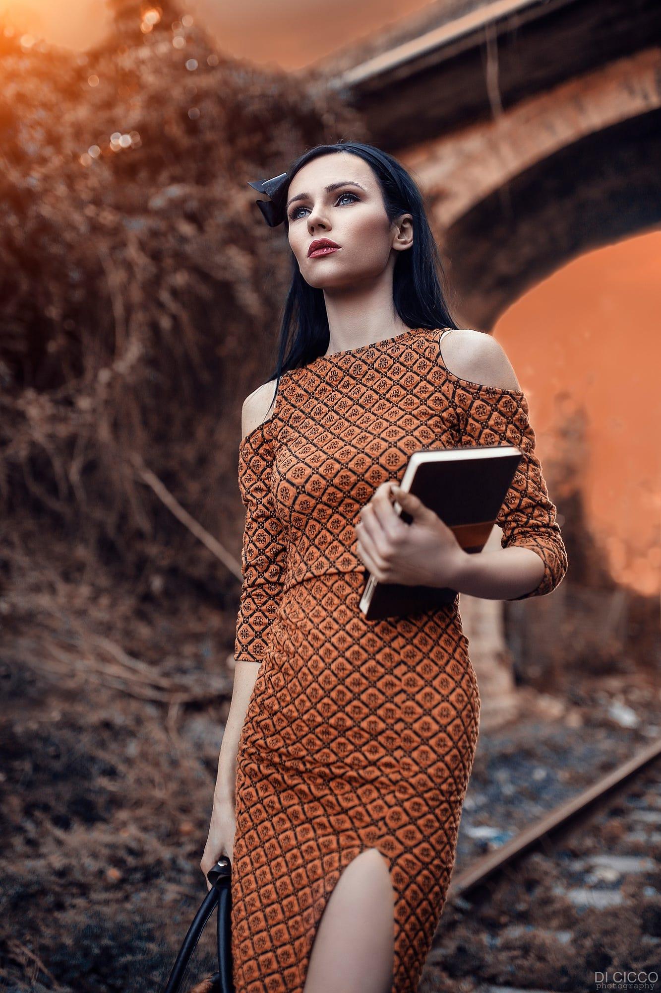 woman with black hair posing on train tracks | Scrolller