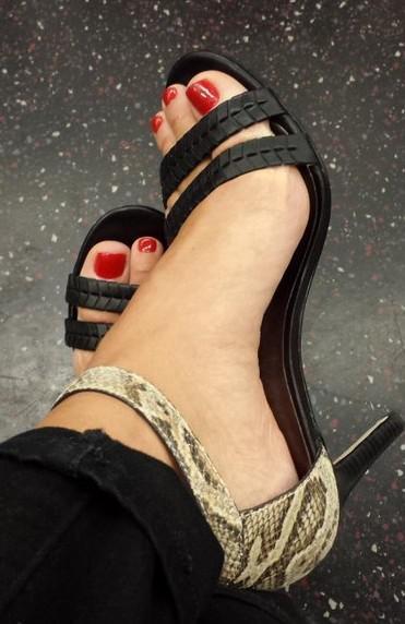 Red pedicured toes in high heel sandals | Scrolller