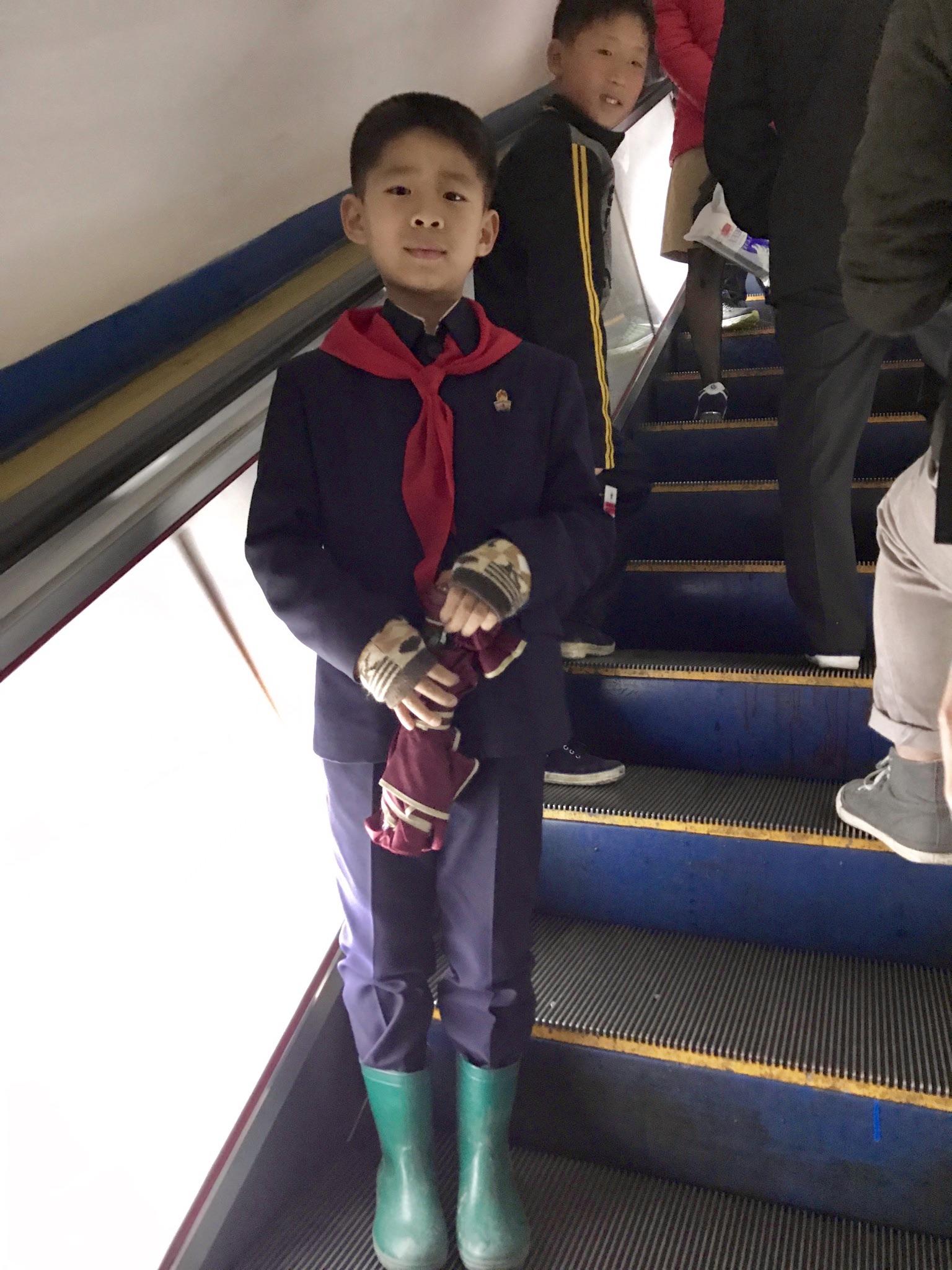 A Young Pioneer proudly posing for a photo on one of the world’s longest metro escalators ...