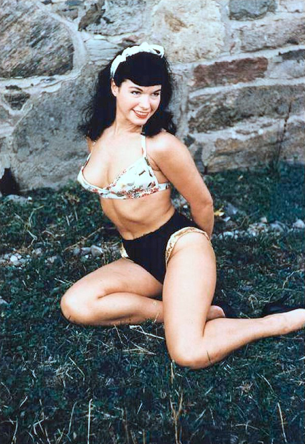 Bettie Page in front of rock wall | Scrolller
