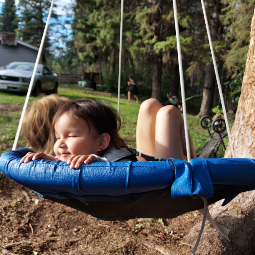 Boy enjoys swinging with his Mom. | Scrolller