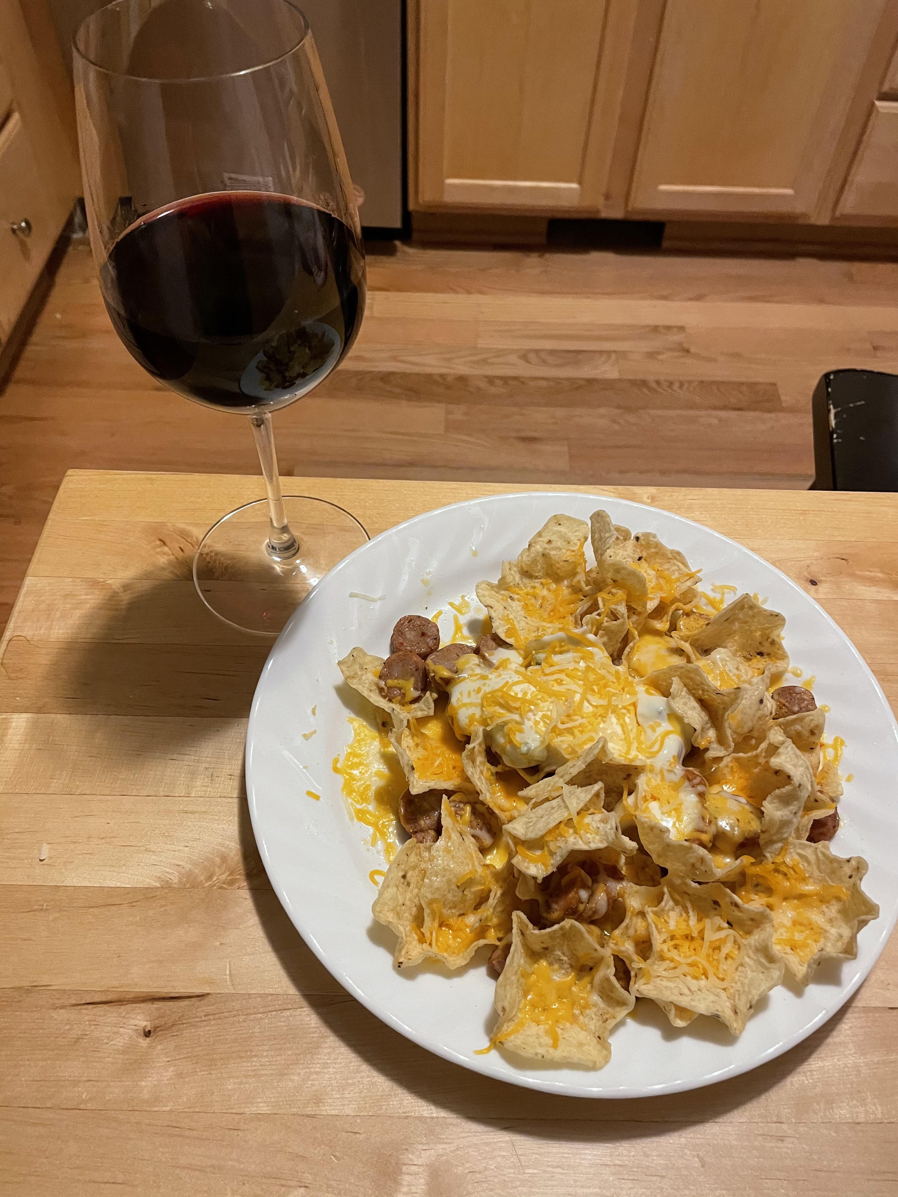 Chicken sausage, tortilla chips with queso dip and shredded cheese and wine | Scrolller