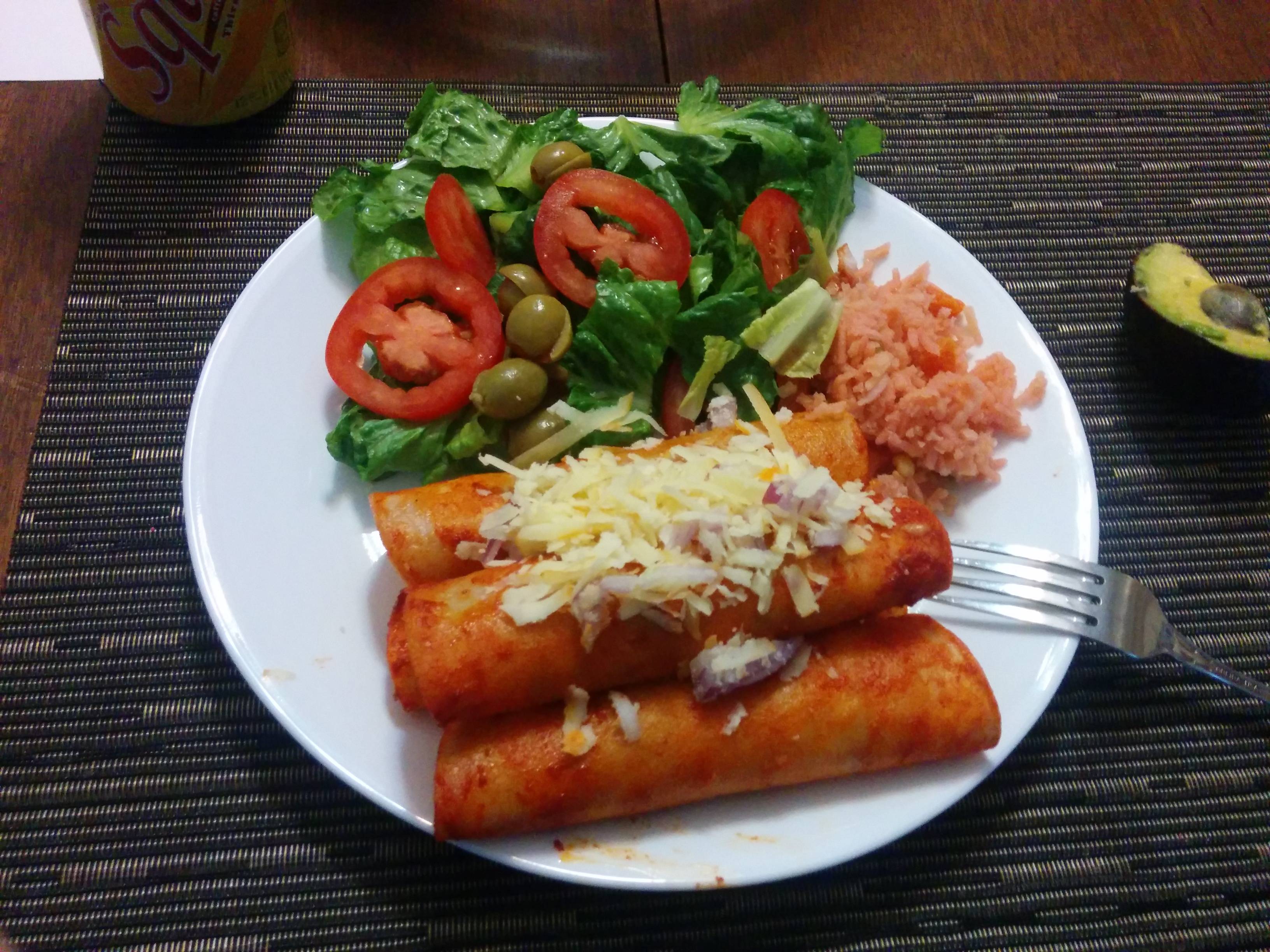 Enchiladas with salad, rice, and half an avocado. | Scrolller