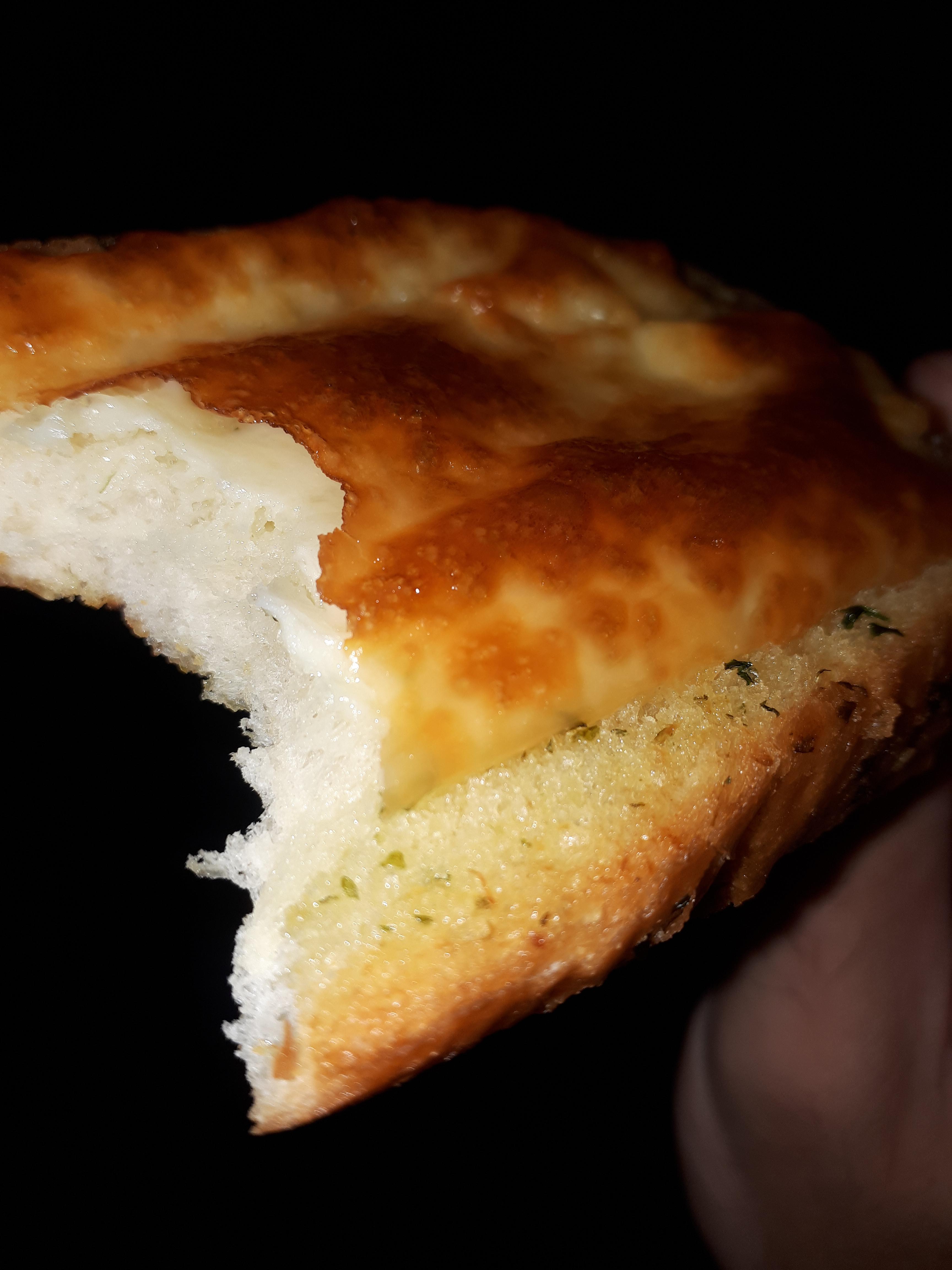 Garlic bread with mozzarella cheese. Featuring a perfectly formed cheese bubble. | Scrolller