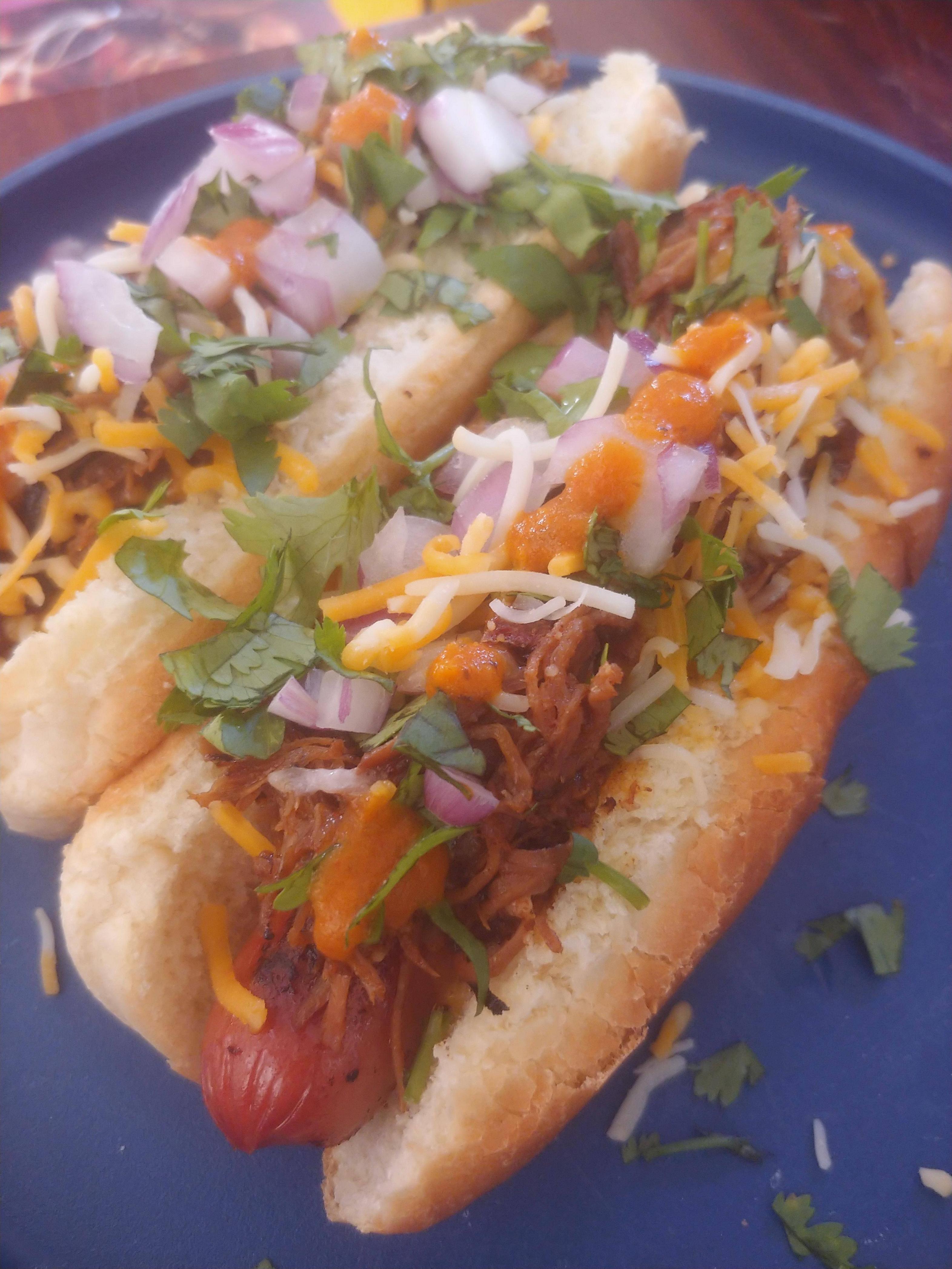 Nathan's with carnitas, shredded cheese, cilantro, red onion and bobby's boat sauce. | Scrolller