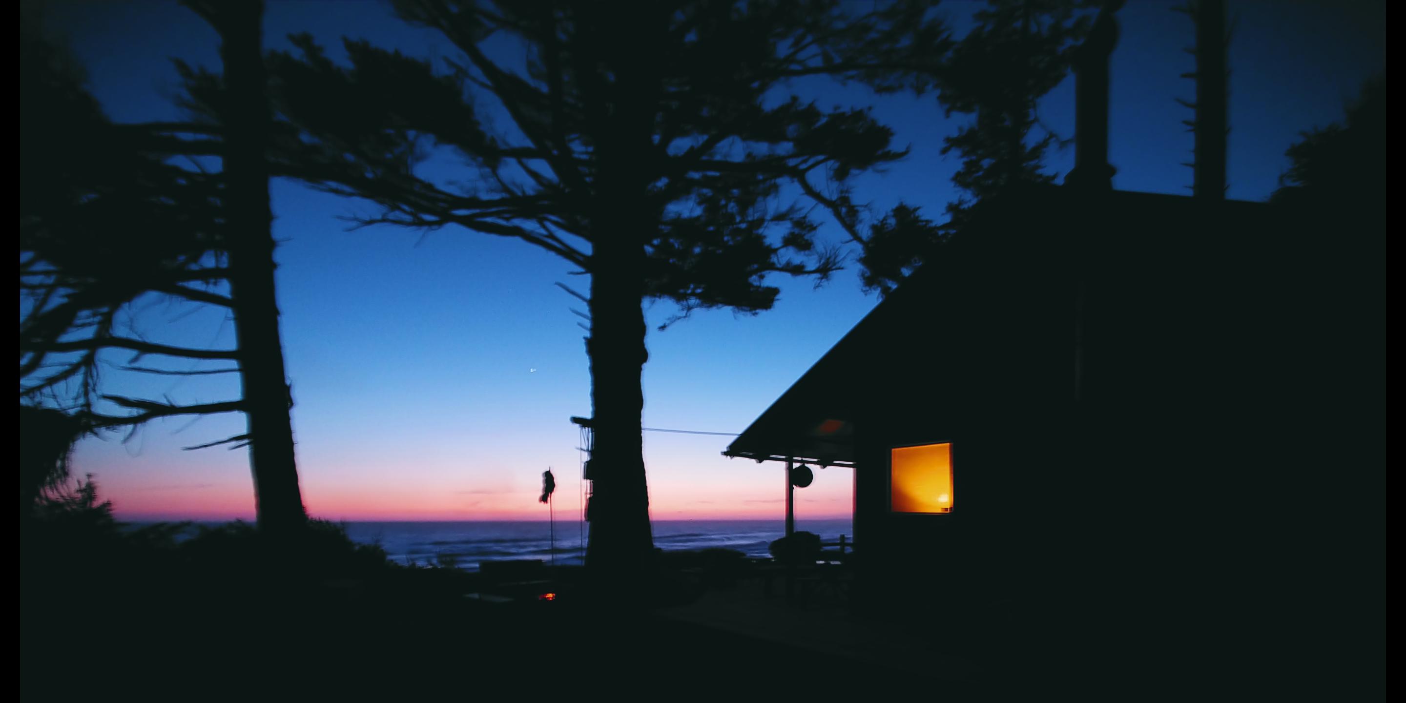 Oceanfront cabin in the Olympic Peninsula at dusk. | Scrolller