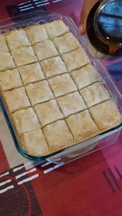 Putting the first layer of hot honey on a crispy Baklava. | Scrolller