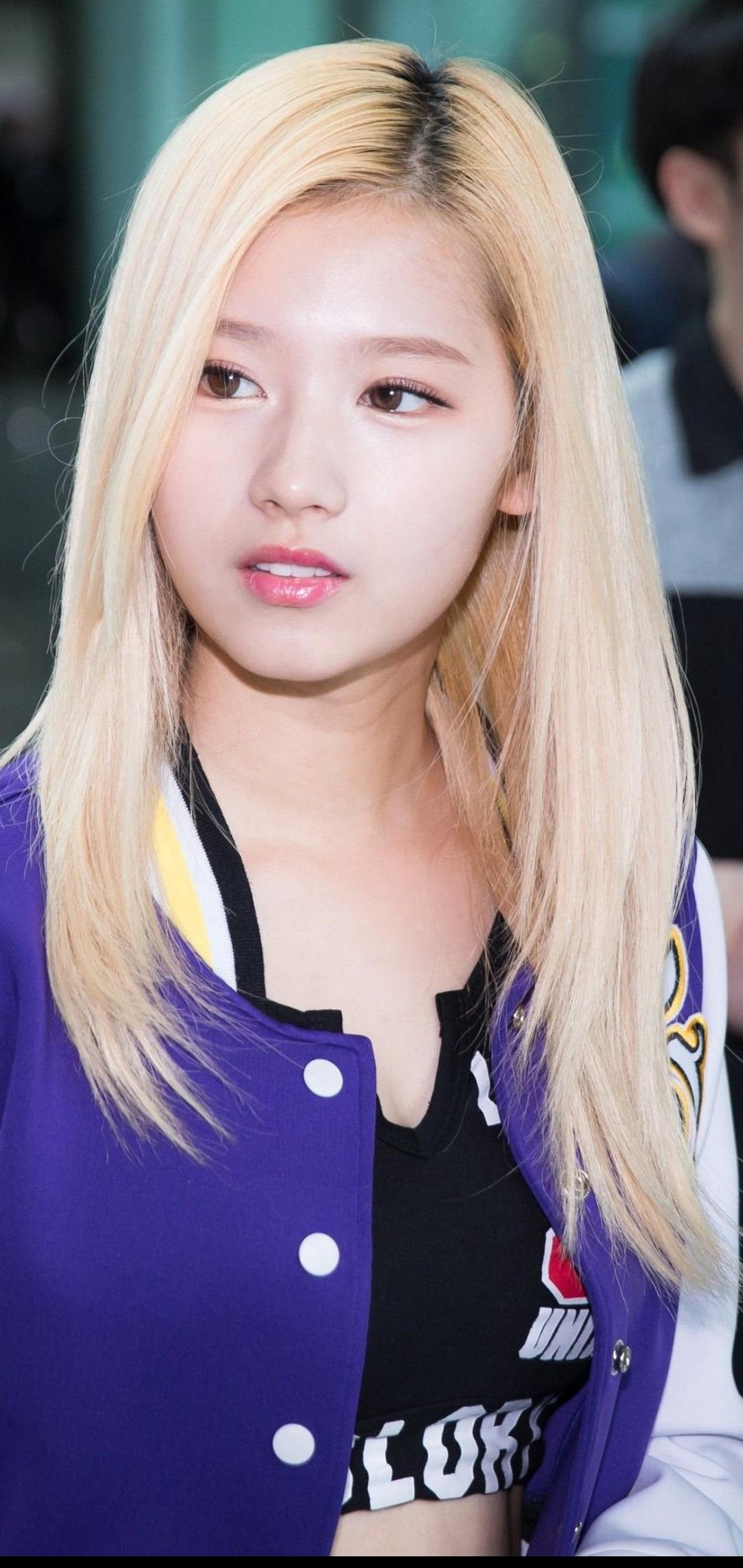 Sana - blonde, purple jacket, black top | Scrolller