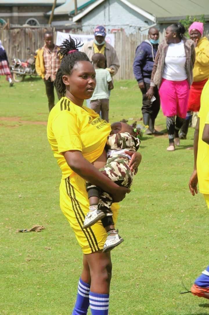 Winnie Wangui Kamau a 23 year old Kenyan "soccer mom" breastfeeding her son during a break in ...
