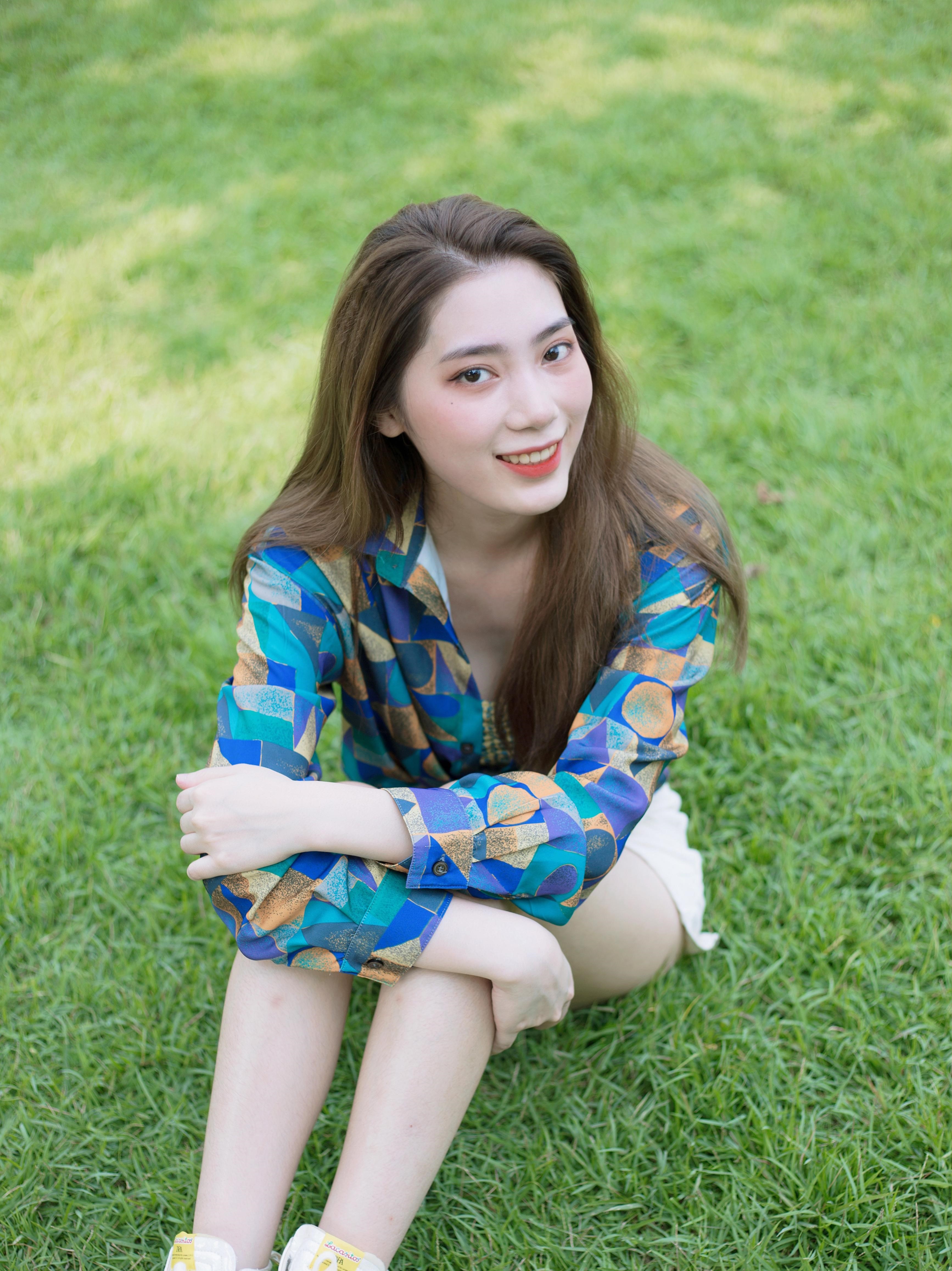 Young girl sitting on grass | Scrolller