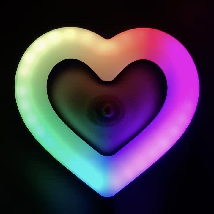 Nipple in the middle of a small kawaii heart ring light with swirling RGB colors | Scrolller
